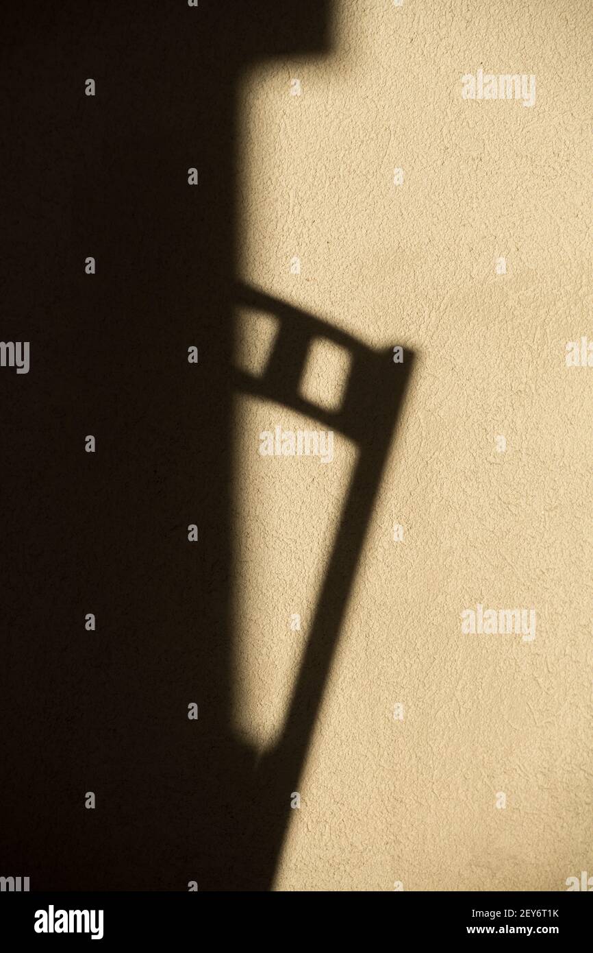 shadow cast onto concrete wall looking like 35 mm film or back of chair ...