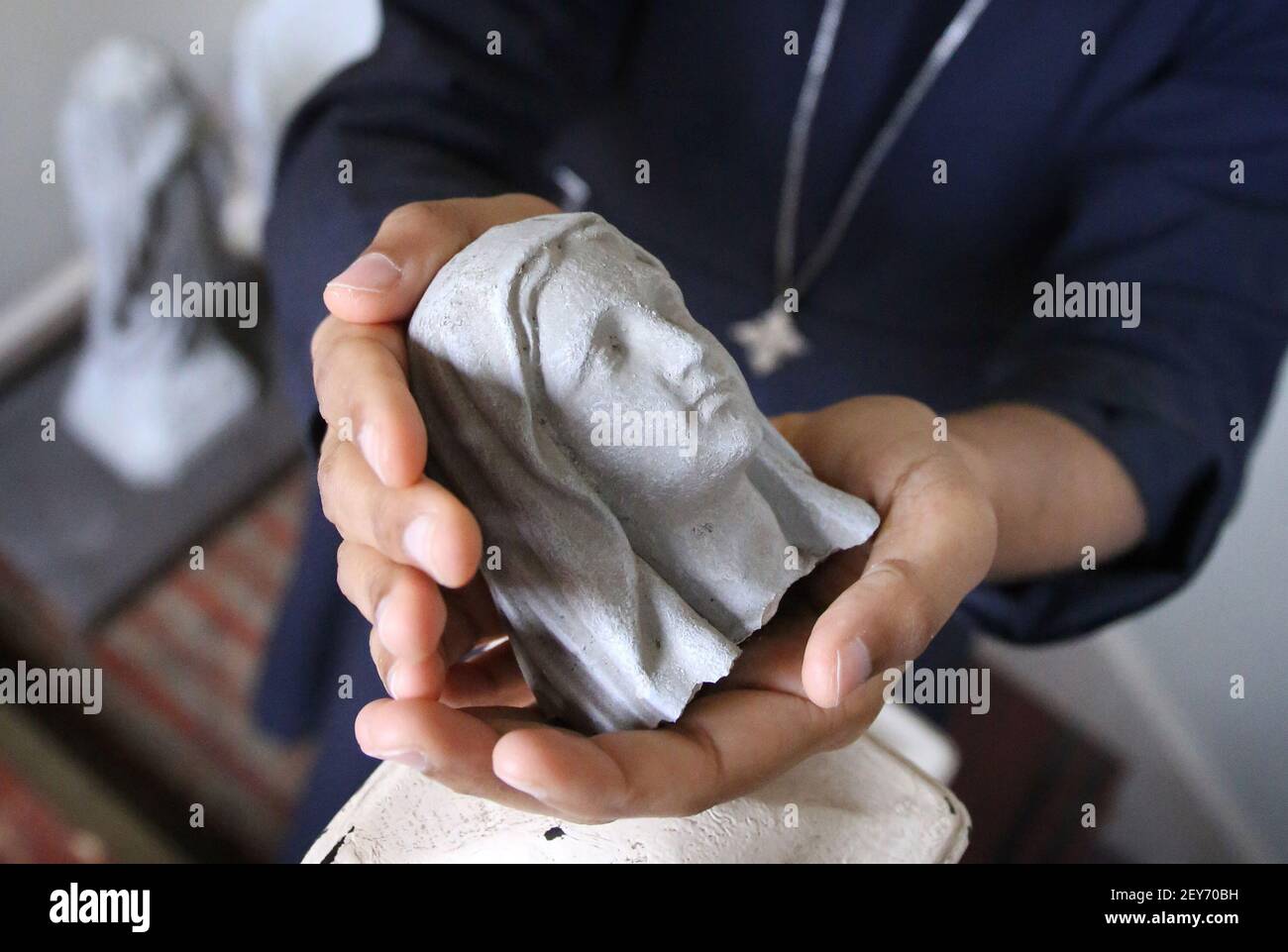 Sister Nirmala Joseph holds a broken head piece from a damaged statue ...