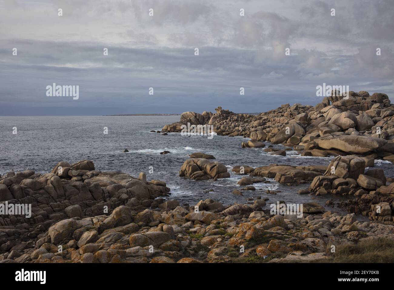 A mesmerizing view of the ocean hitting the rocky coast gleaming under ...