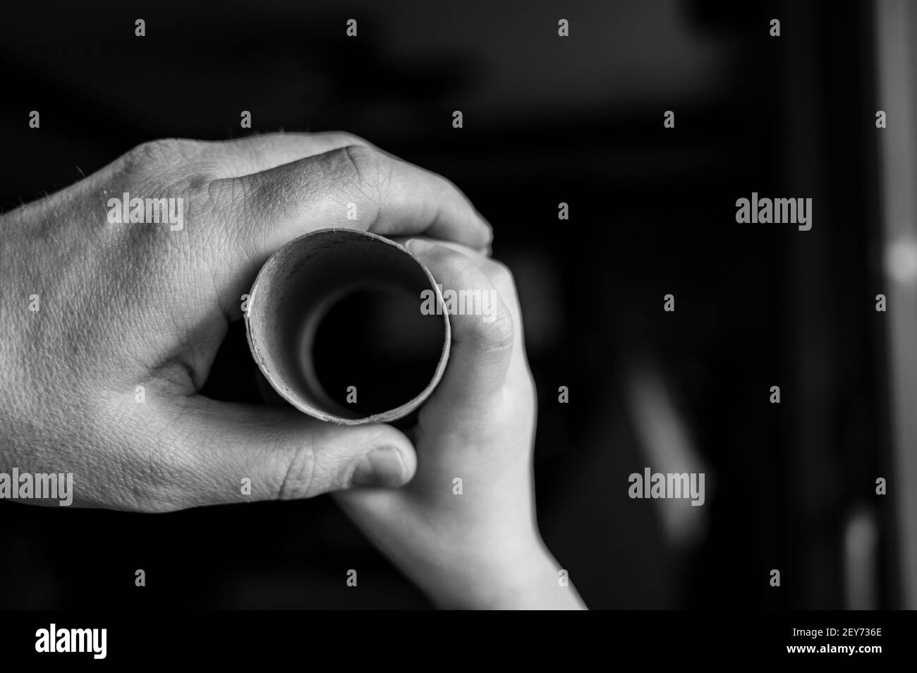 Father and Child using imagingation to play with a cardboard tube as a ...