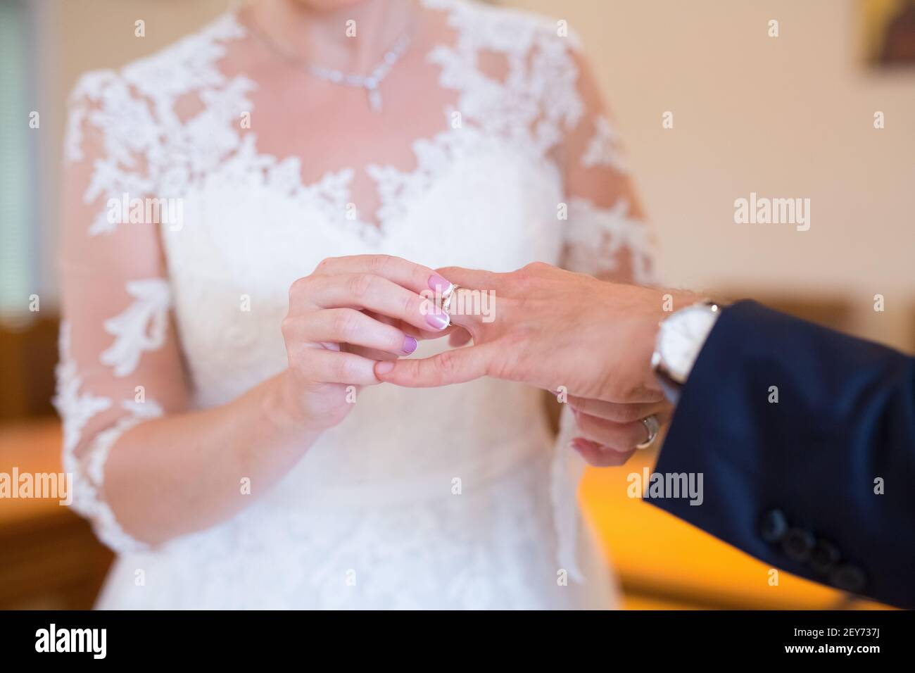 Groom wearing golden ring for his bride, soft focus Stock Photo - Alamy