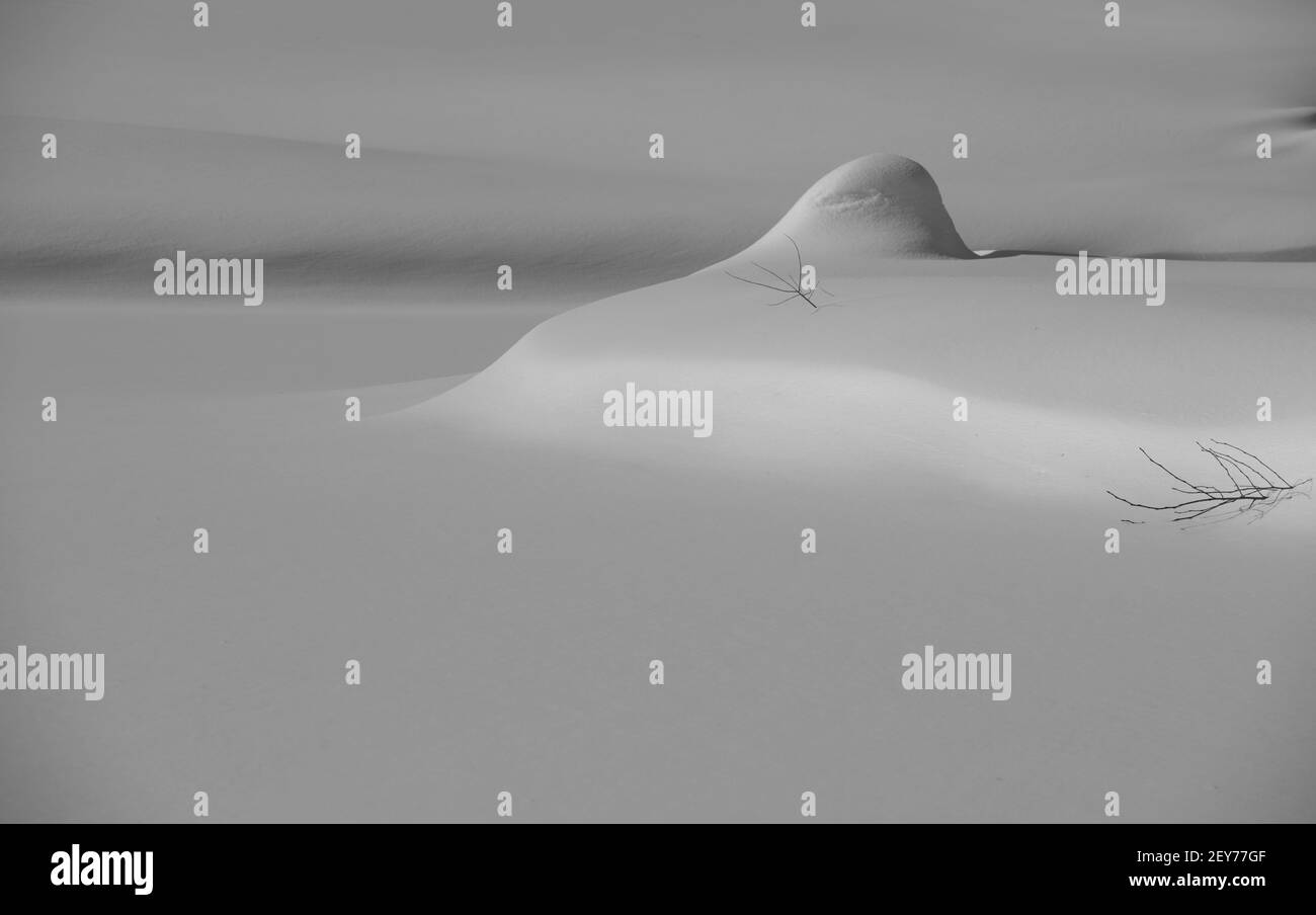 snow mound surrounded by fresh snow curves in white snow shadows and ...