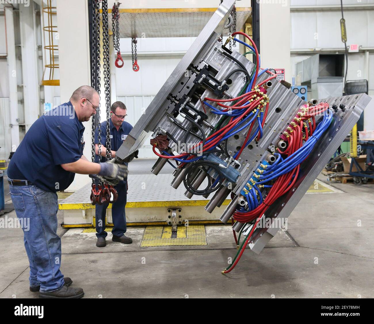 Chad Willsnack, front left, and Scott Biertzer ready a mold for use in ...
