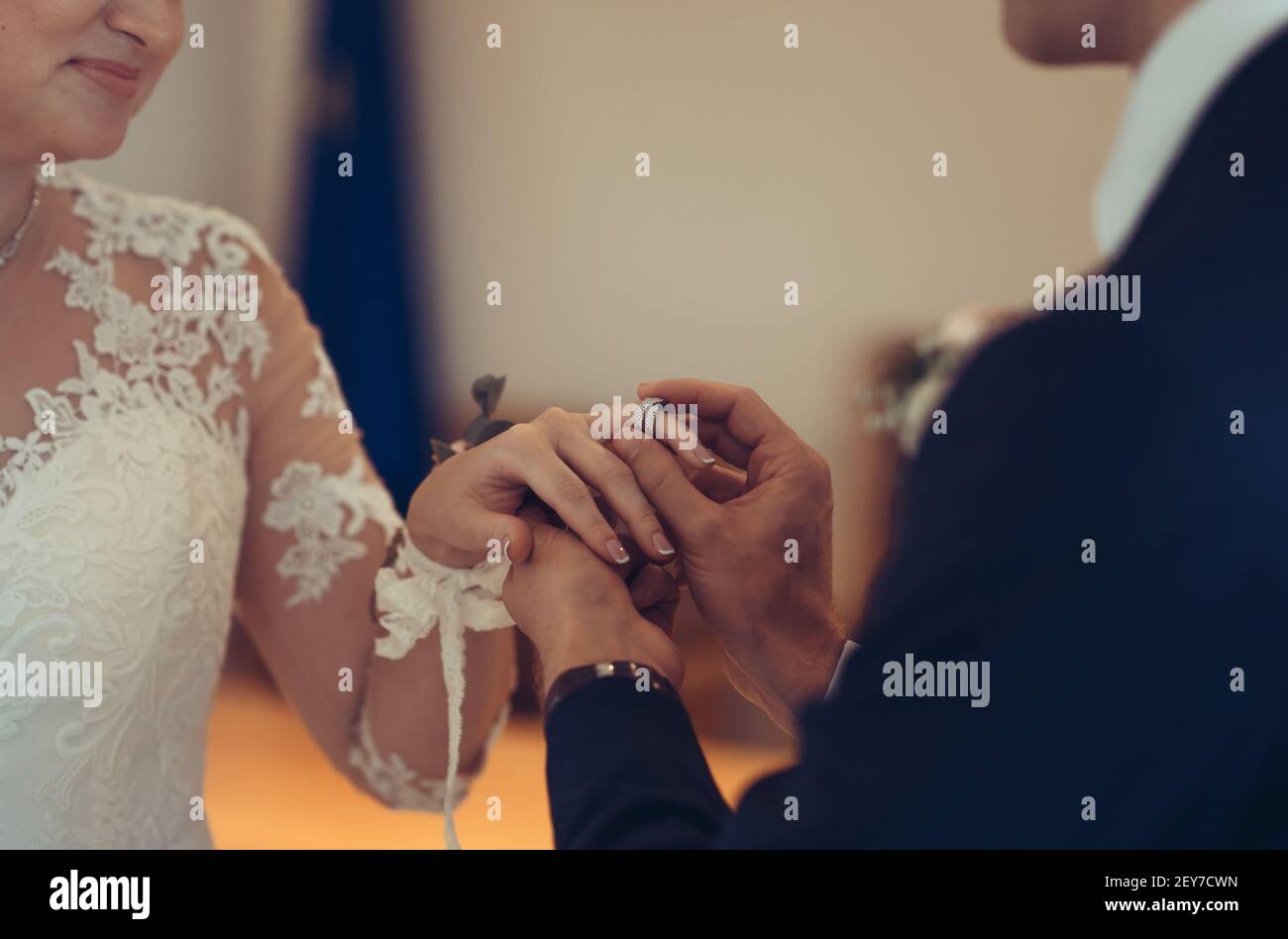 Groom wearing golden ring for his bride, soft focus Stock Photo - Alamy