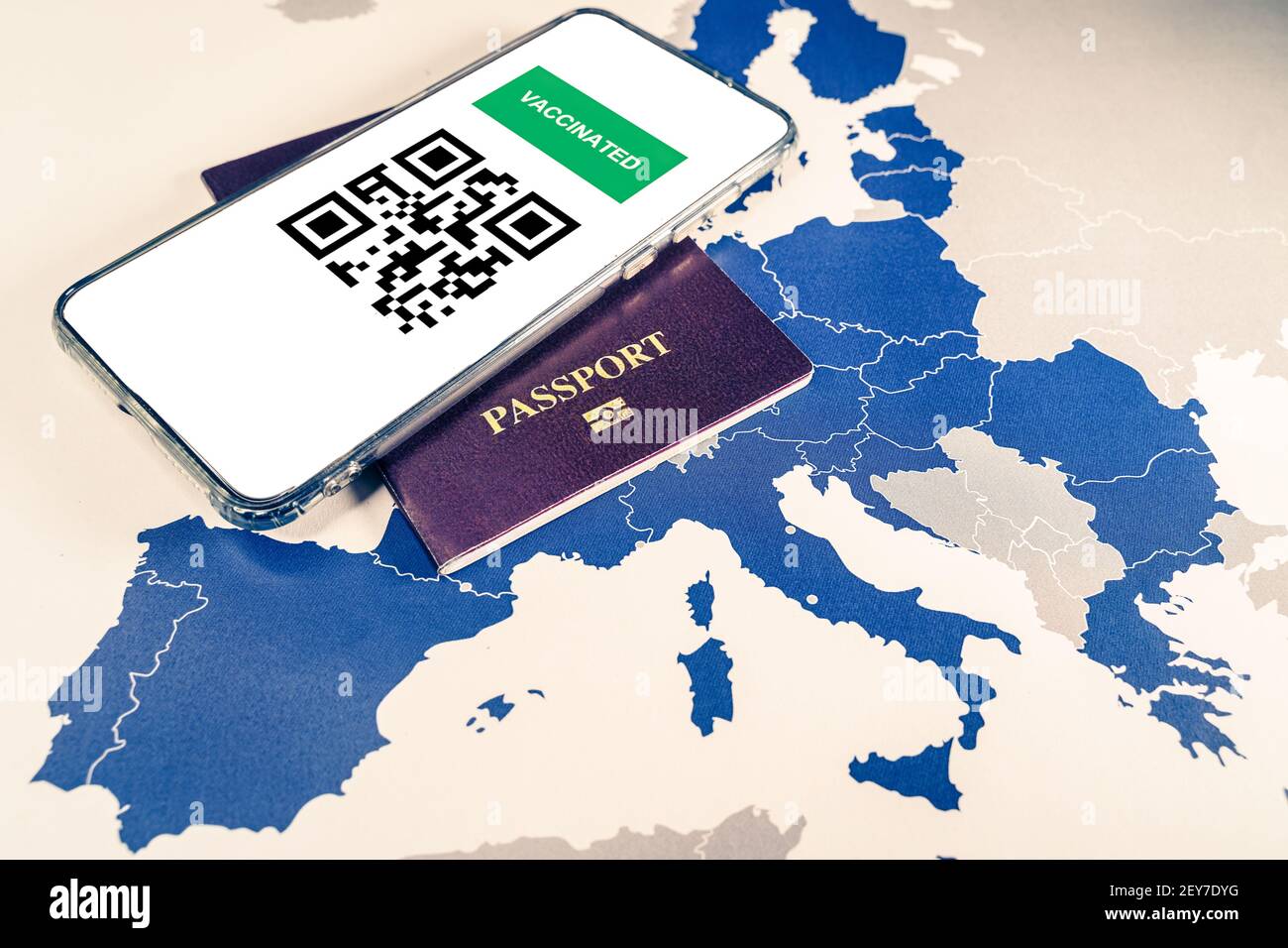 Digital green passport with QR code on a smartphone over an EU map ...