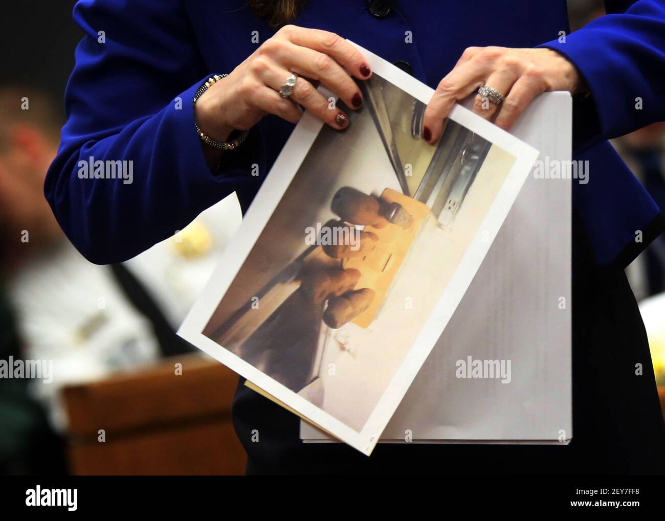 Prosecutor Gail Levine holds a photo of a wooden block of knives with ...