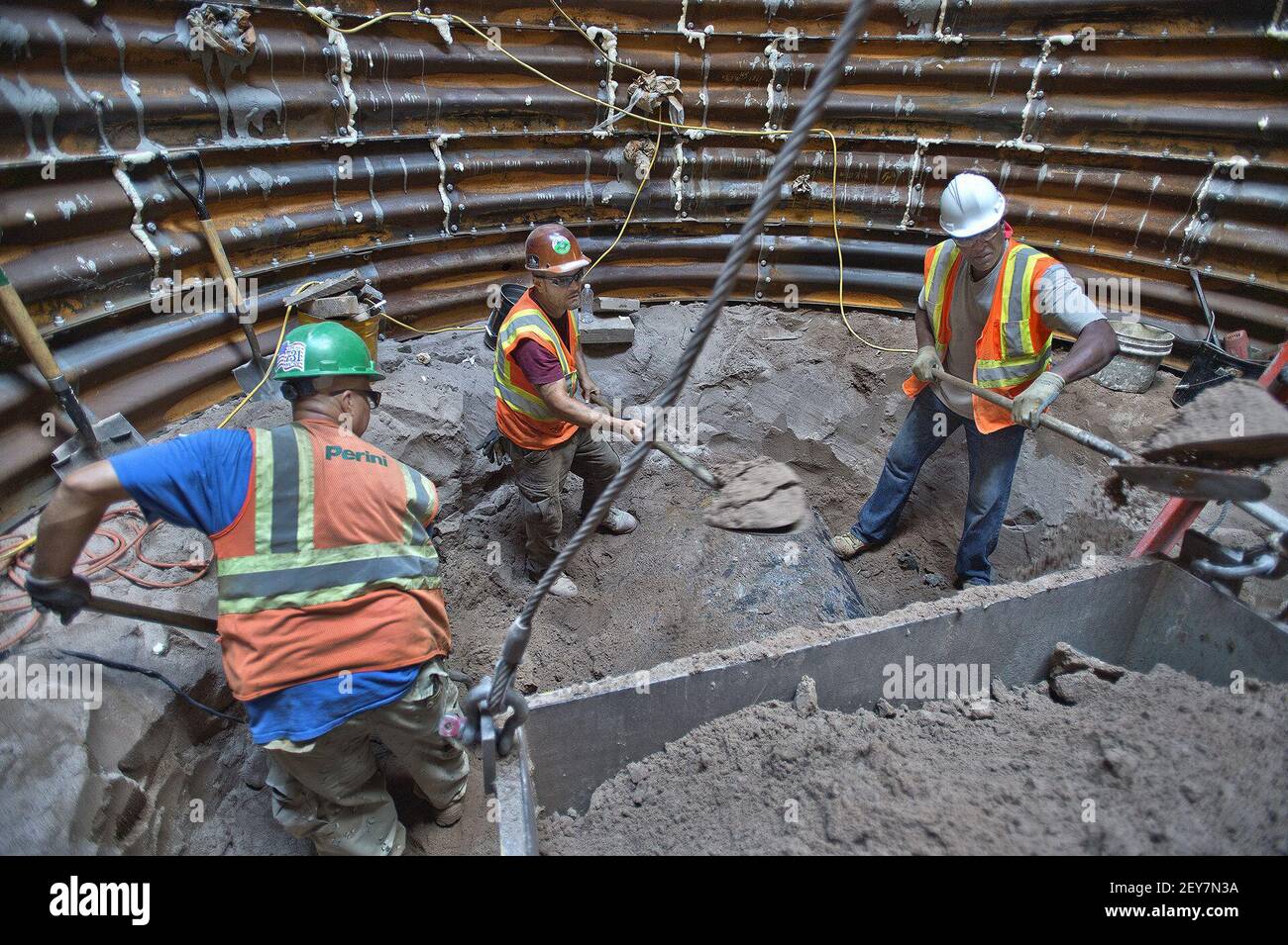 Workers in manhole digging around steel encased microtunnel. as part of ...