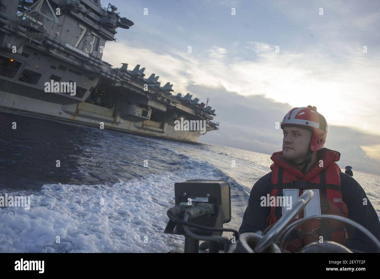 U.S. Navy Boatswain's Mate 2nd Class Joshua Dingman maneuvers a rigid ...