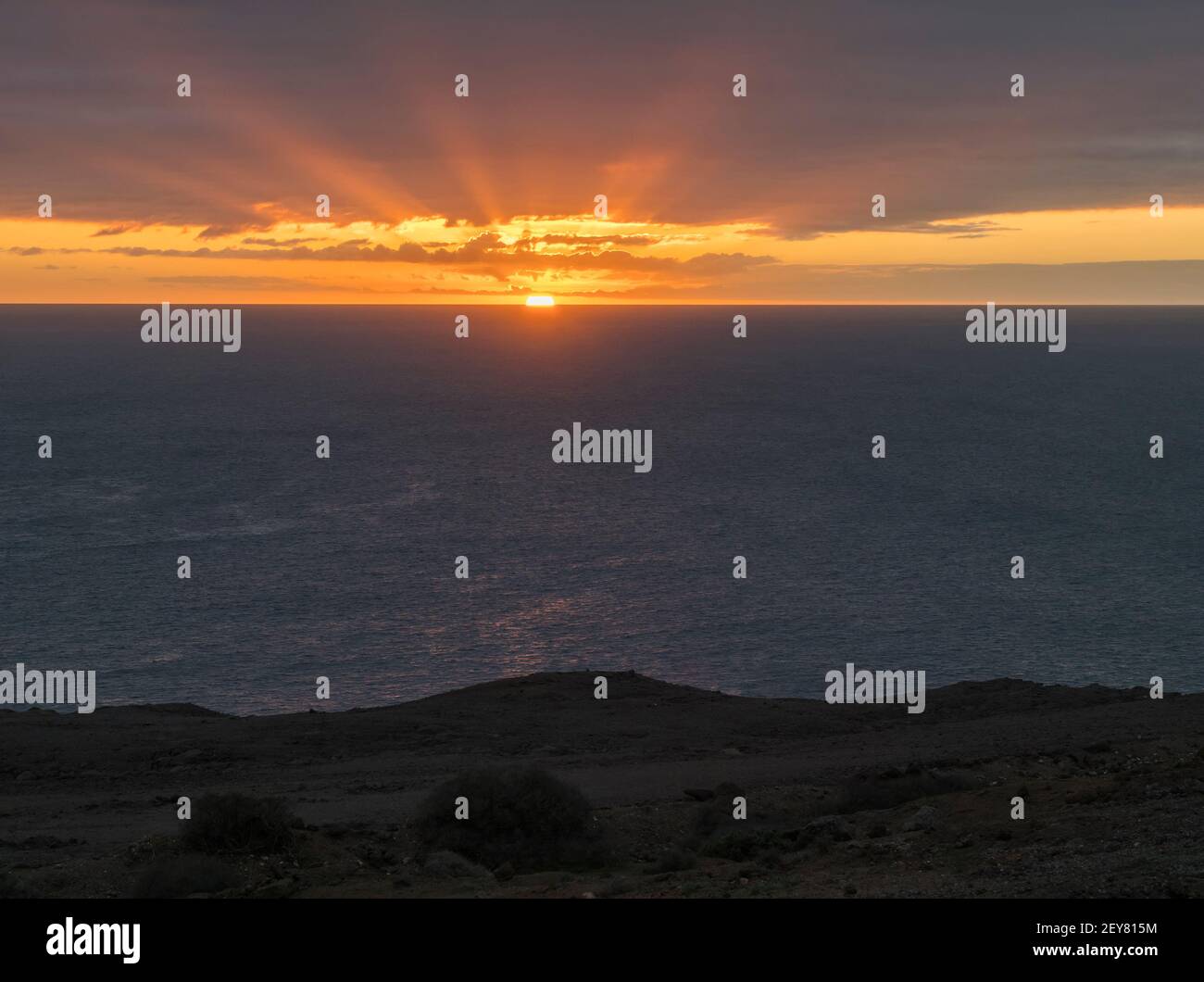 Beautiful sunset with red orange sun with rays going down to the ...