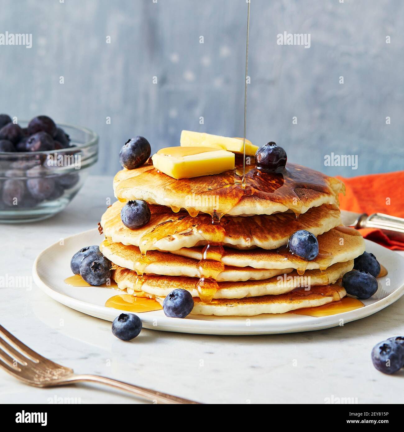 Pancake stack with blueberries and syrup pour Stock Photo - Alamy