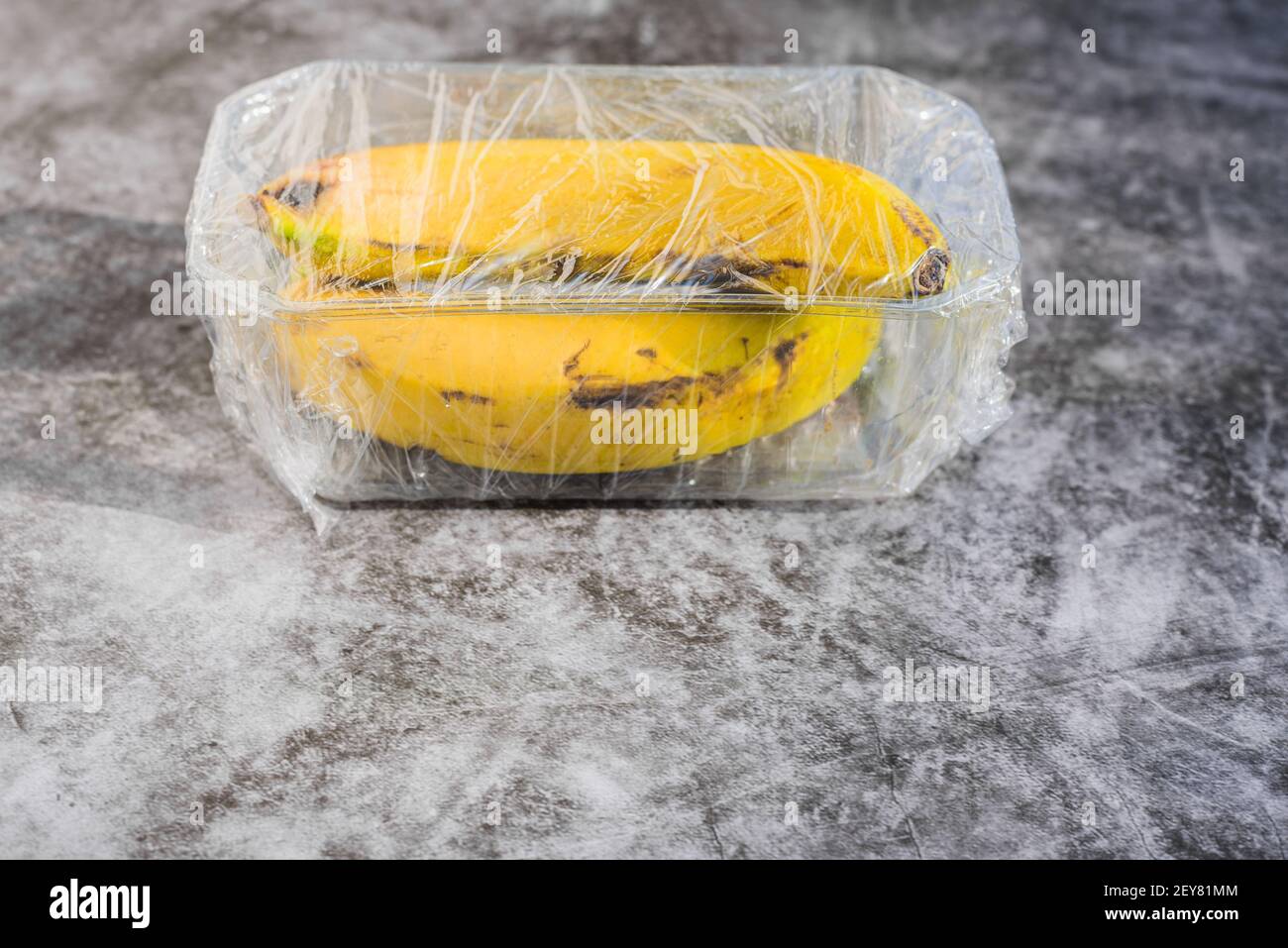 Bananas with natural peel wrapped in pointless plastic packaging Stock ...