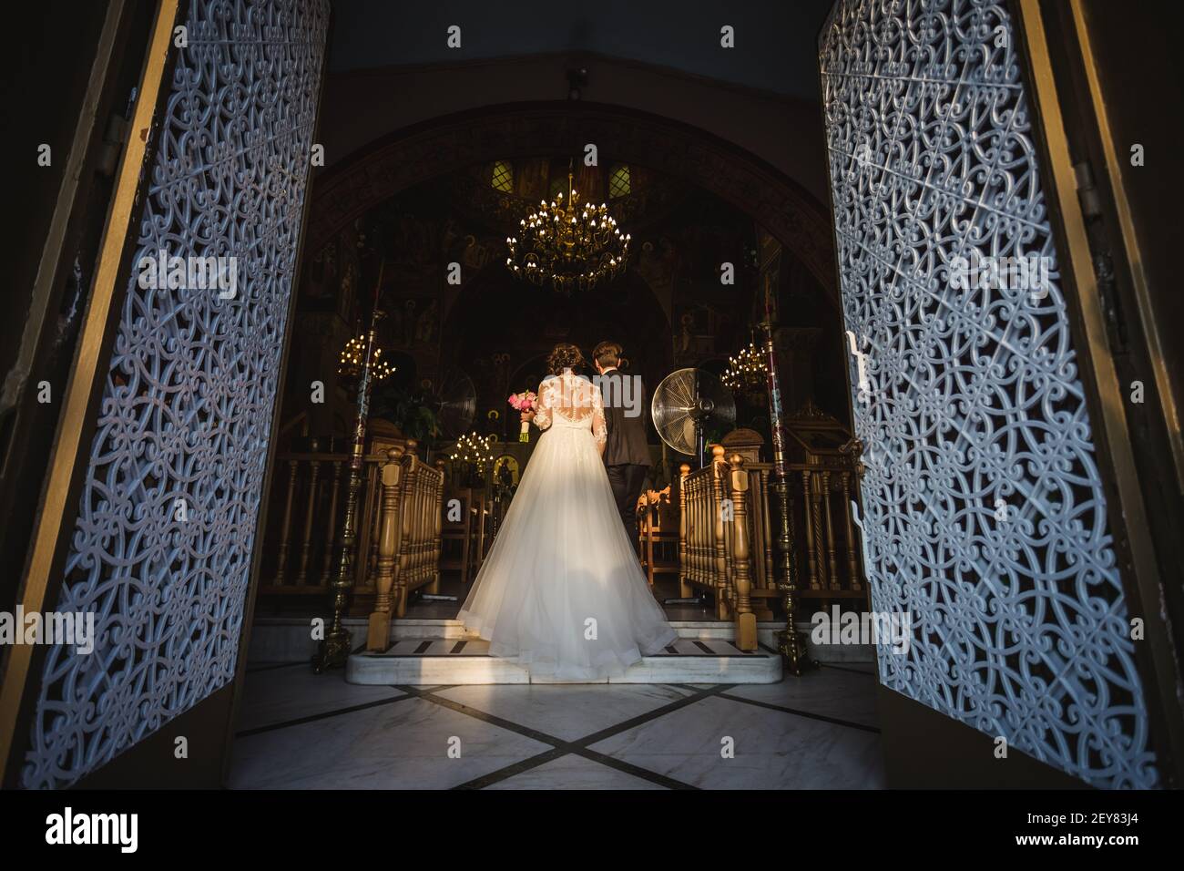 back view of bride and groom walking to the altar Stock Photo - Alamy