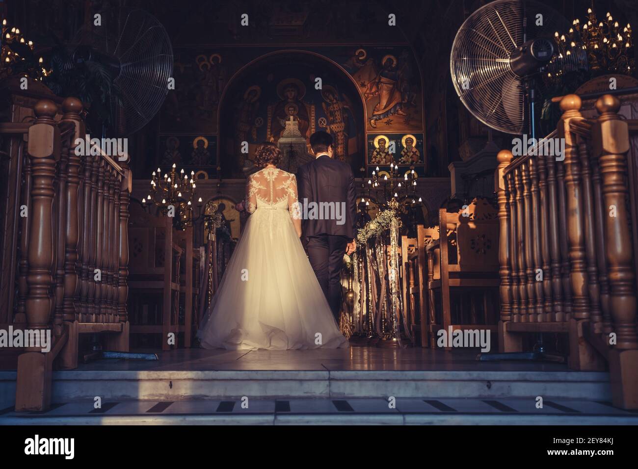 back view of bride and groom walking to the altar Stock Photo - Alamy