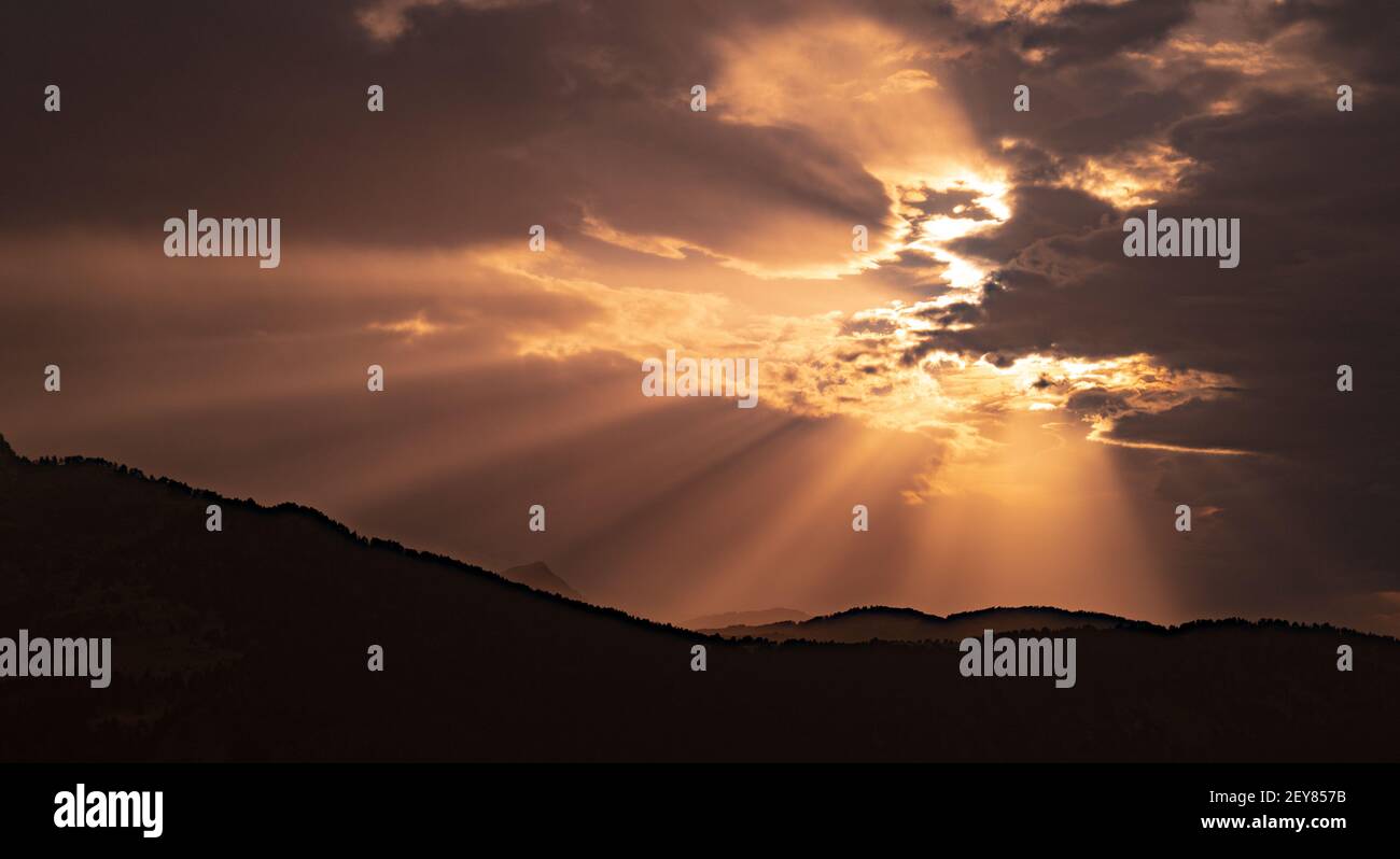 Rays of light filtering through the clouds in a beautiful sunset or ...