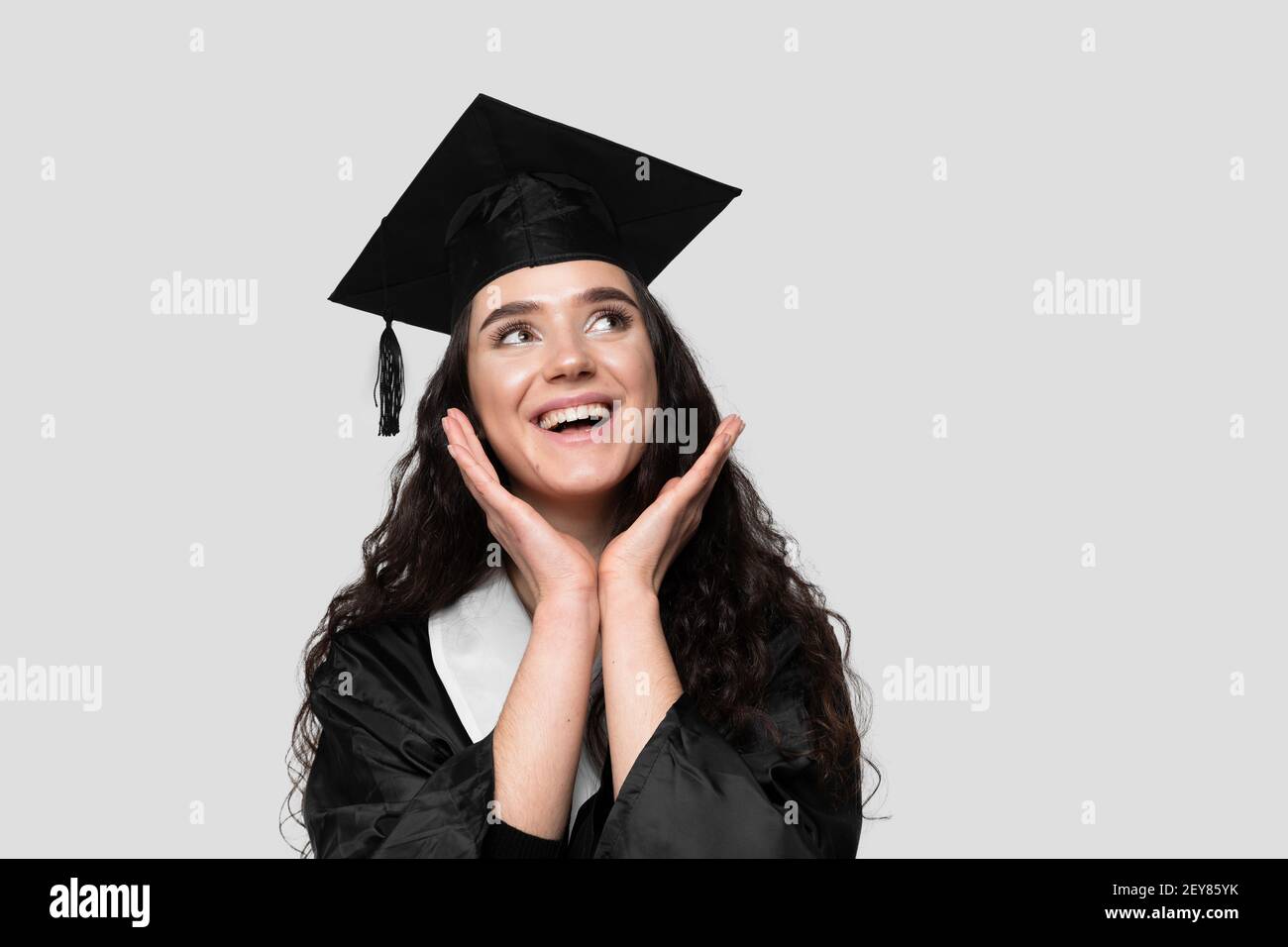 Graduate girl with master degree in black graduation gown and cap on ...