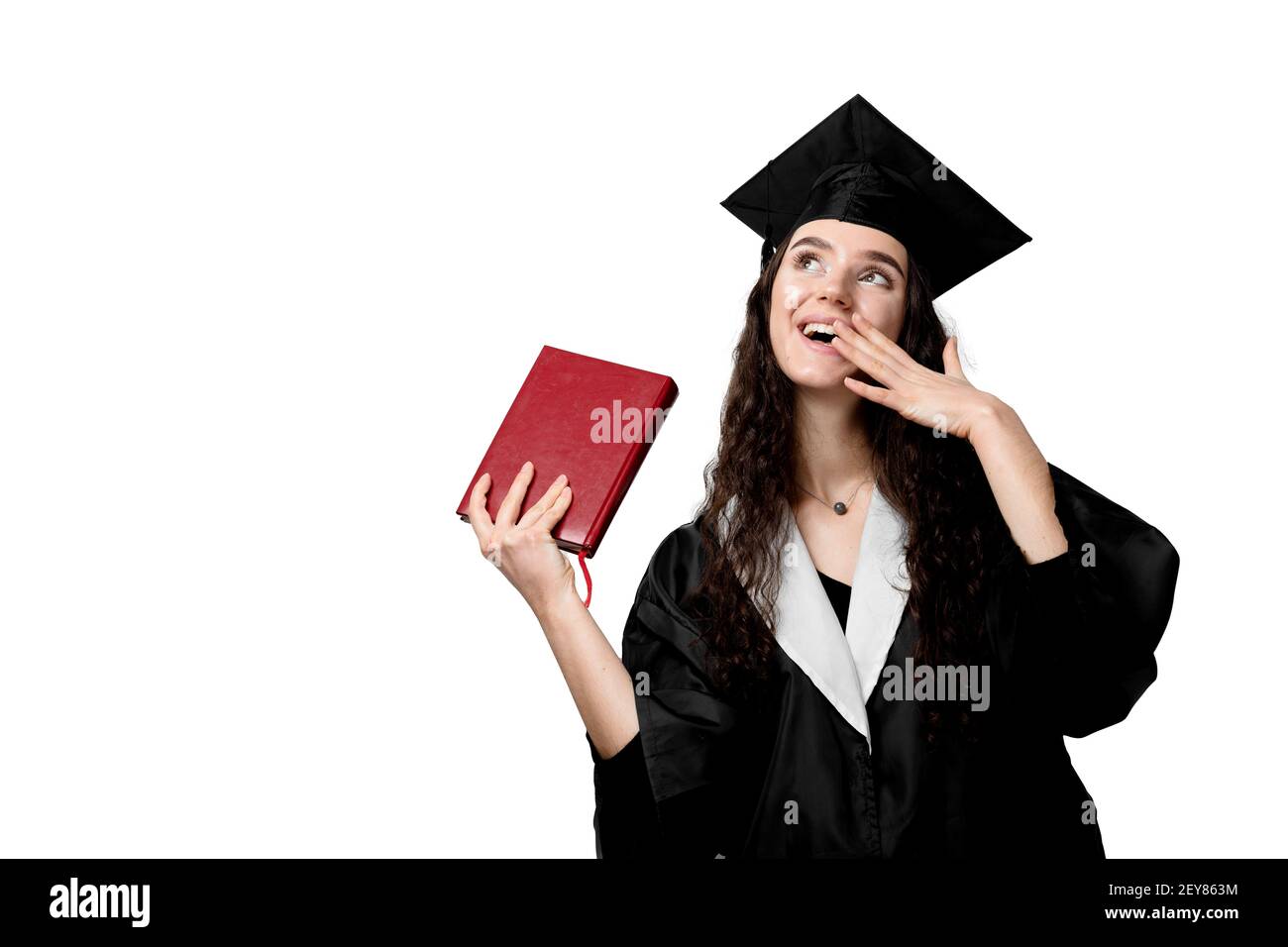 Student with book in graduation robe and cap ready to finish college ...