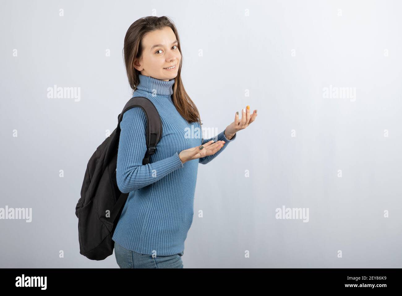 Portrait photo of a young girl model standing with backpack and posing ...