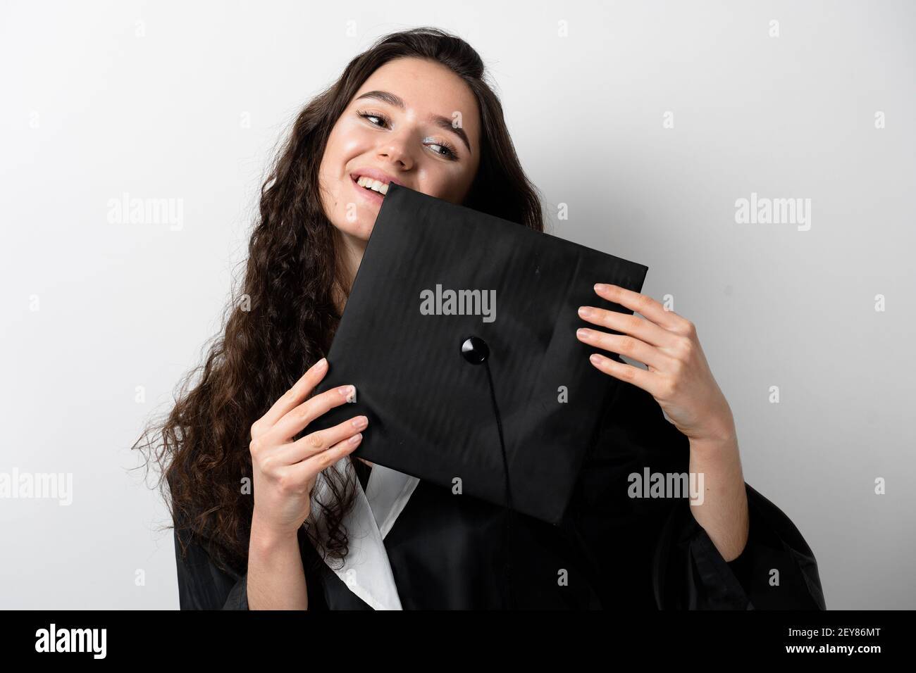 Graduate girl with master degree in black graduation gown and cap on ...