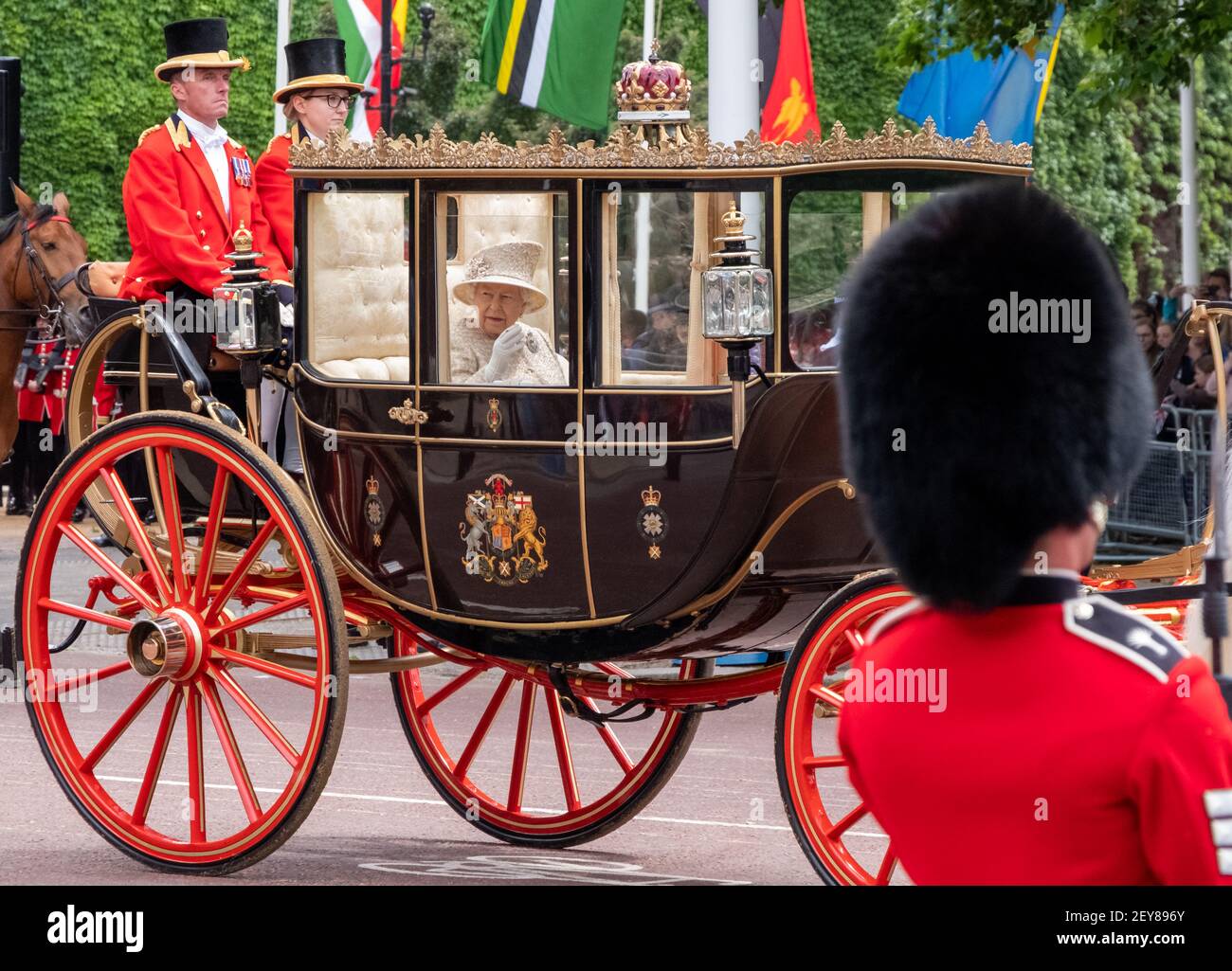 Queen Elizabeth II in a carriage pulled by horses, on her way to ...
