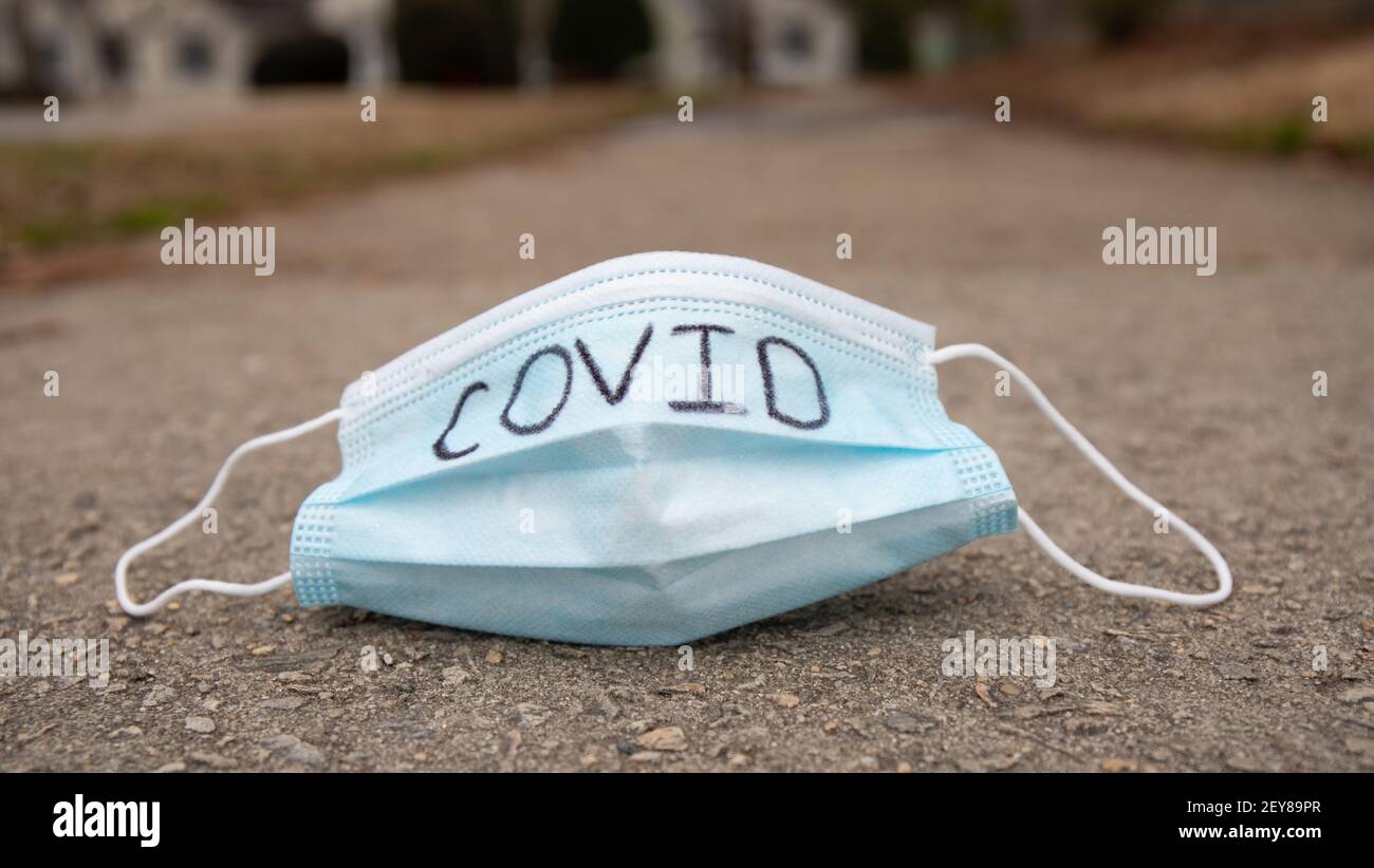 Up close bokeh photo of a mask with the word covid written on it laying ...