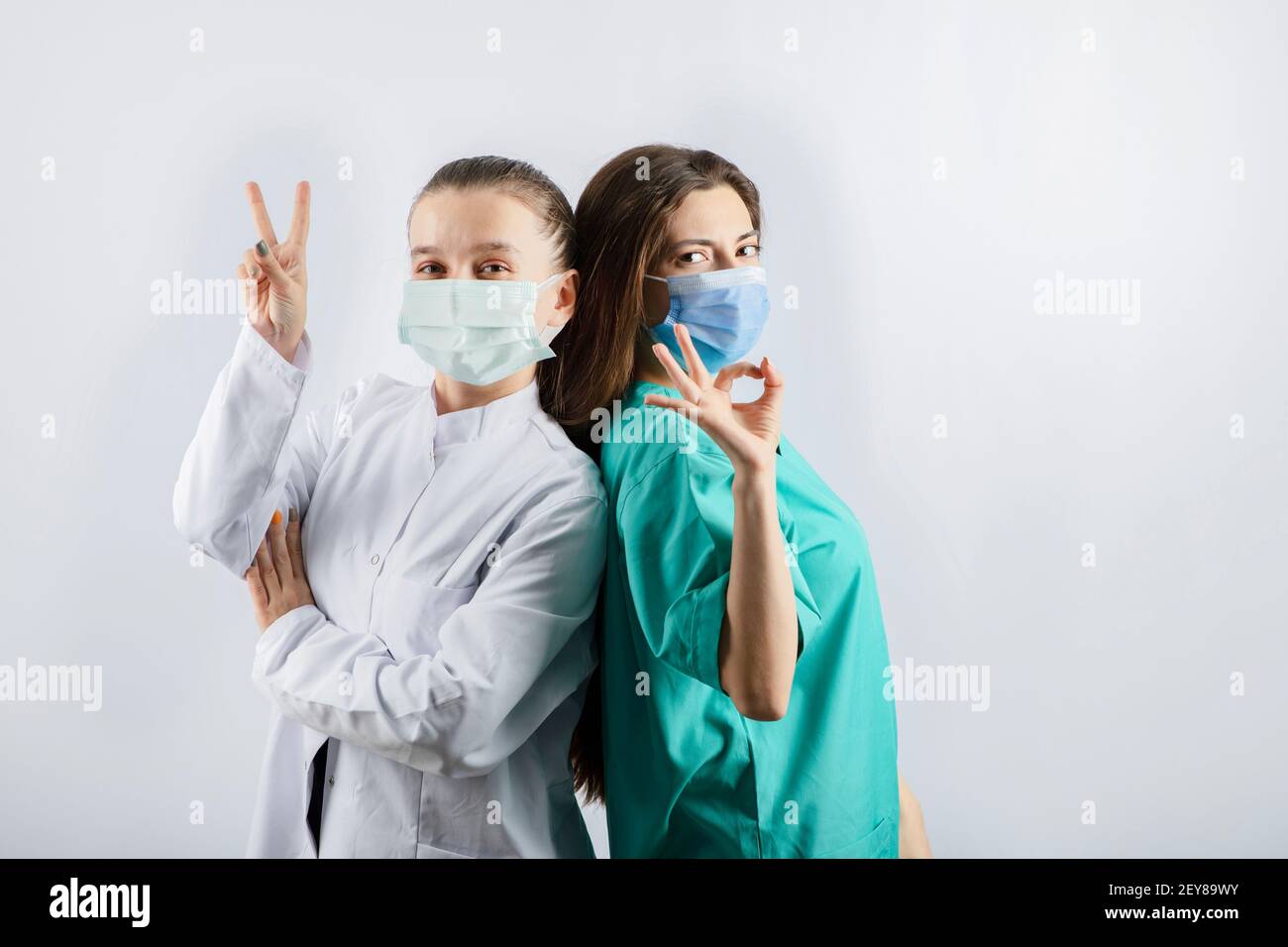 Female doctor in white uniform showing victory sign and nurse Stock ...