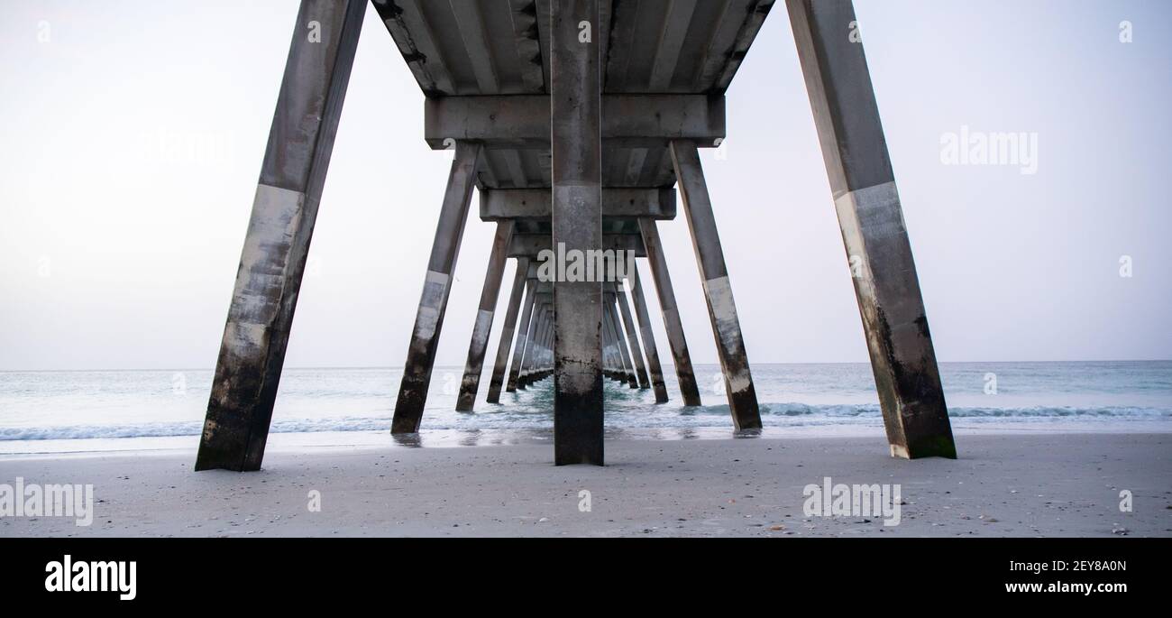 Underneath an ocean pier with symmetrical lines Stock Photo - Alamy