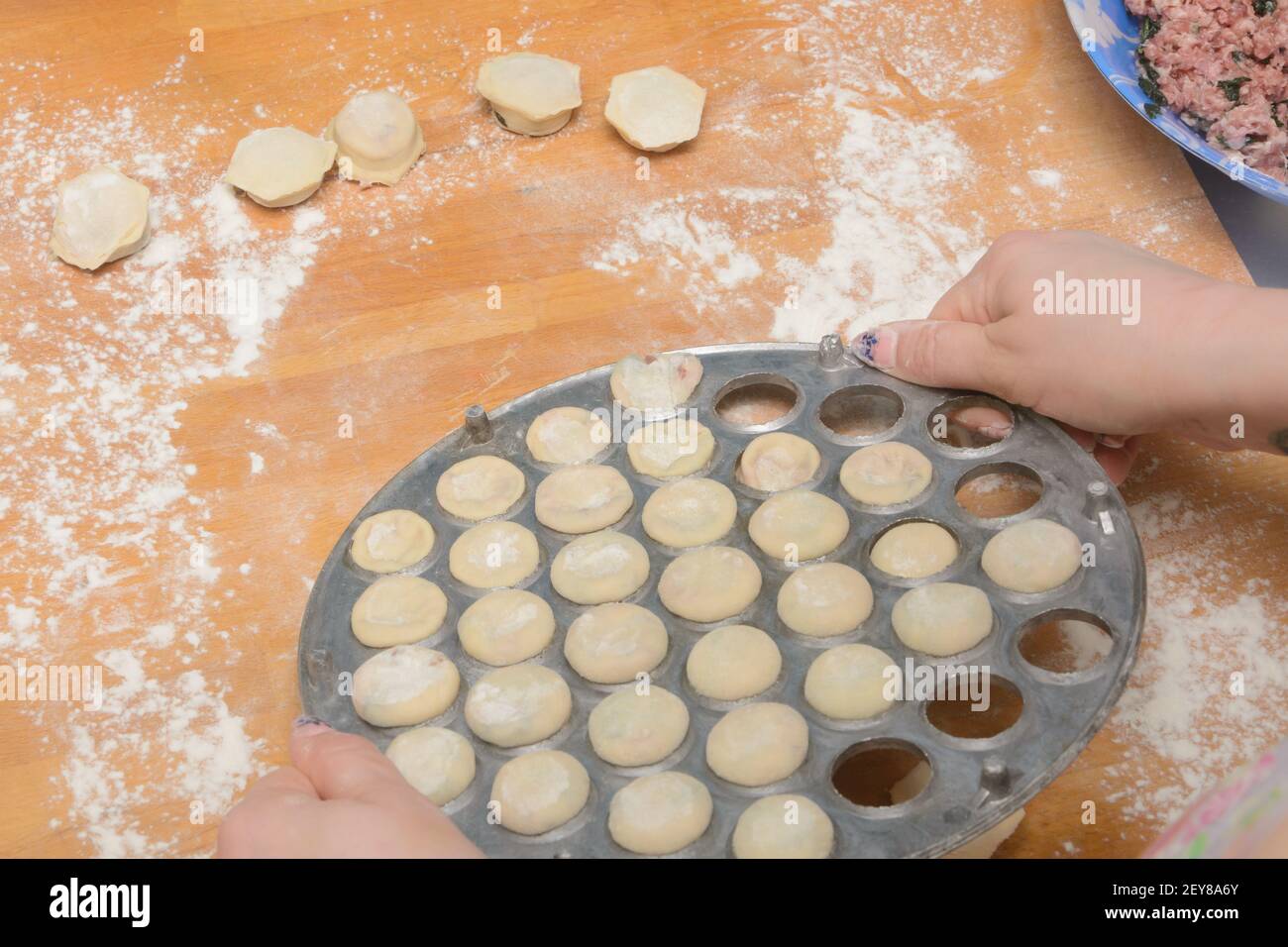 Cooking homemade dumplings in special round form. Fast food preparation ...