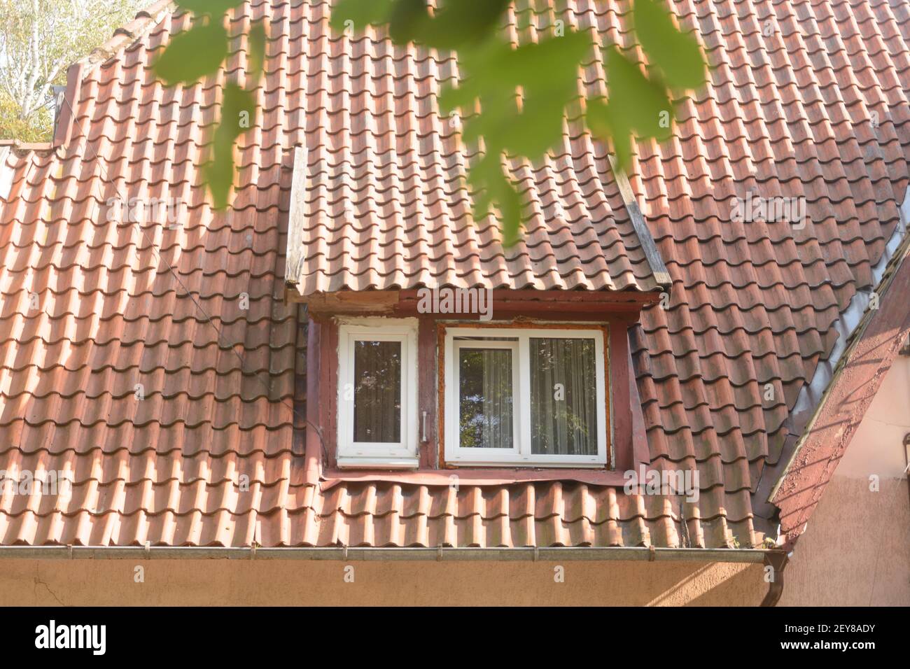 Window in old attic with tiled roof. Part of facade building from last ...