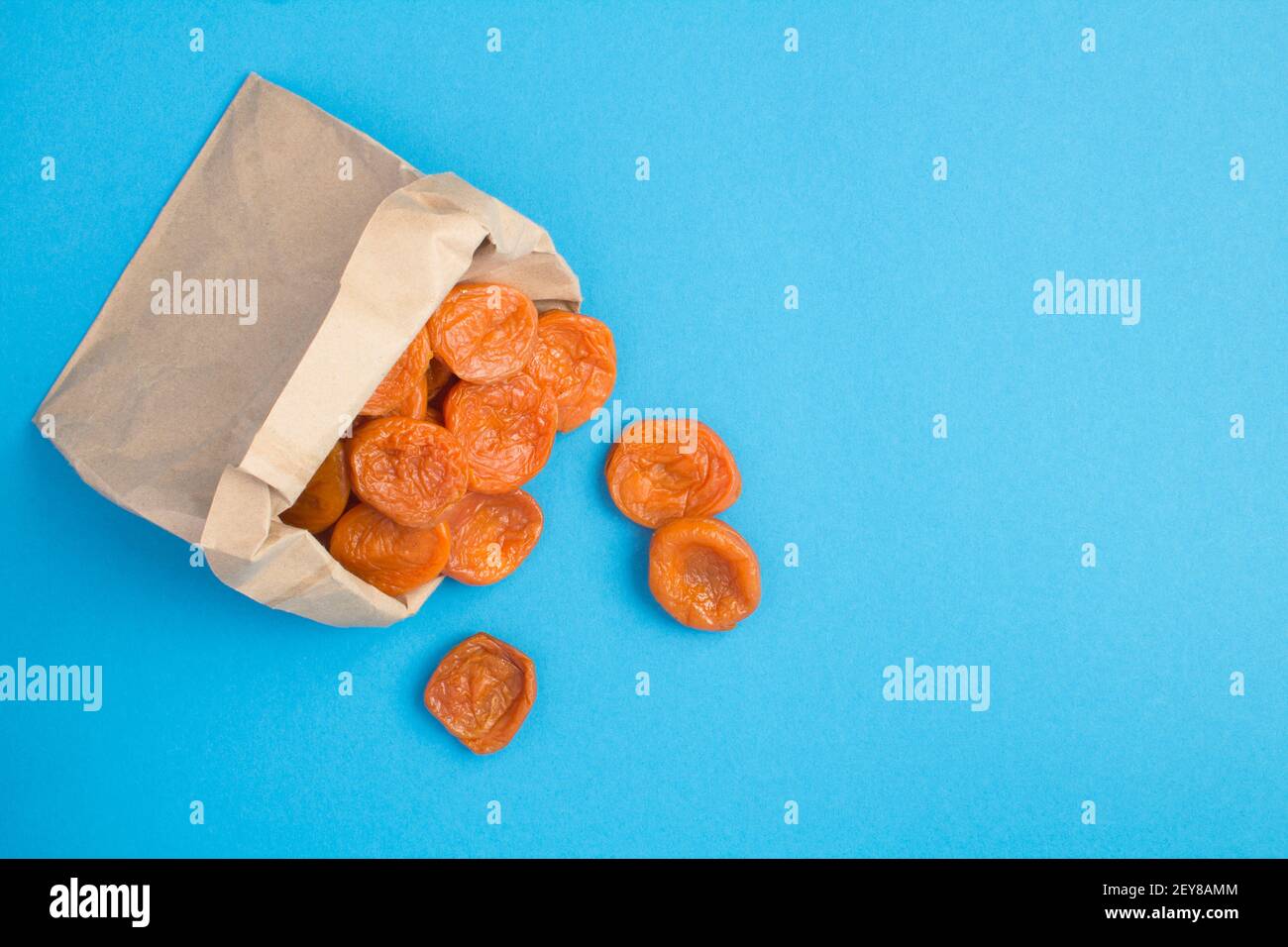 Top view of dried apricots in a paper bag on the blue background Stock ...