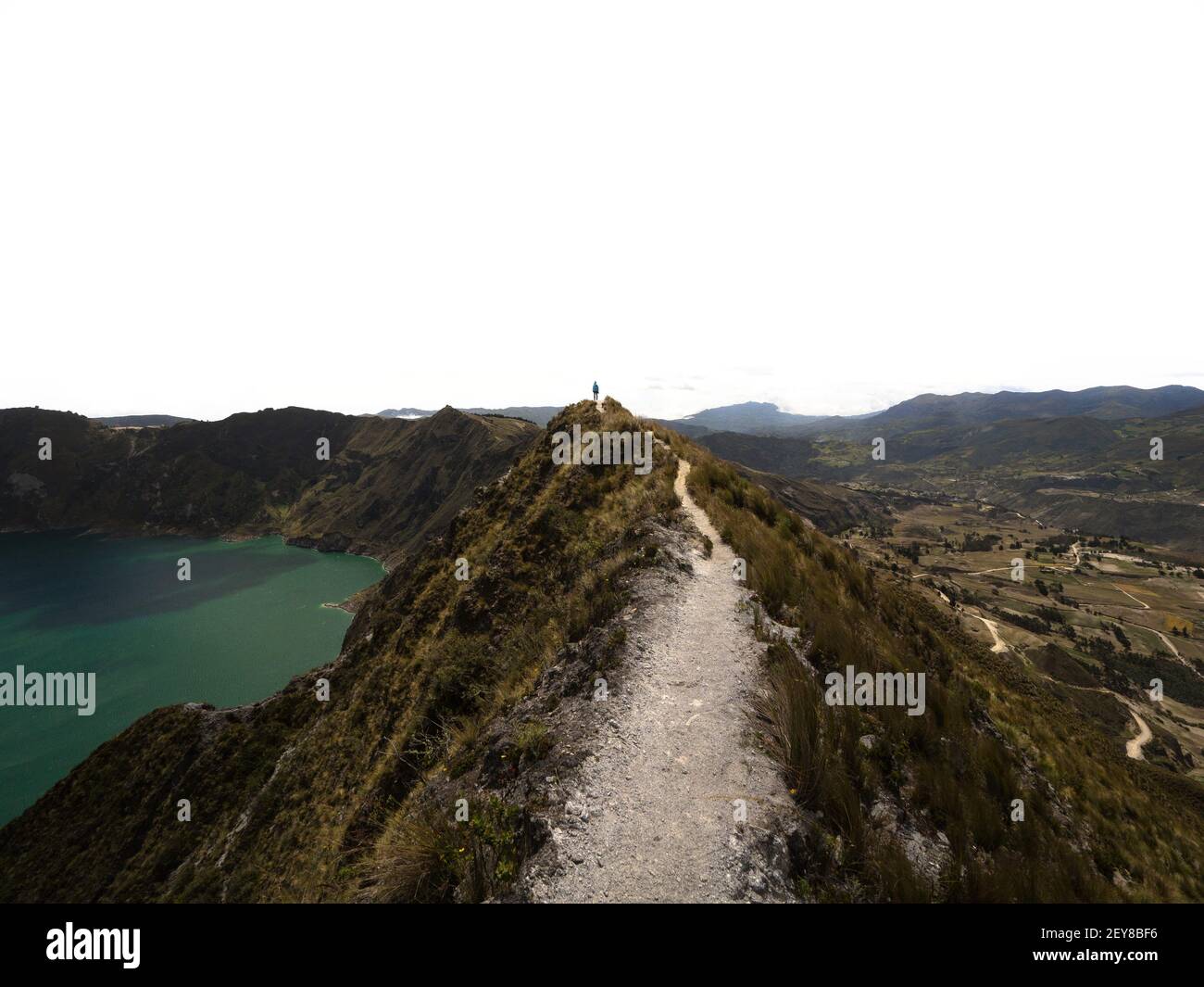 Young hiker standing on andean volcano caldera crater lake Quilotoa rim ...