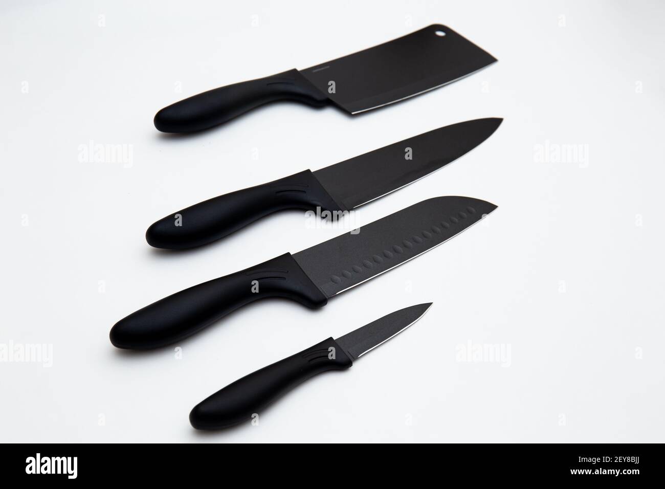 A side view of different sized black matte sharp knives evenly arranged ...