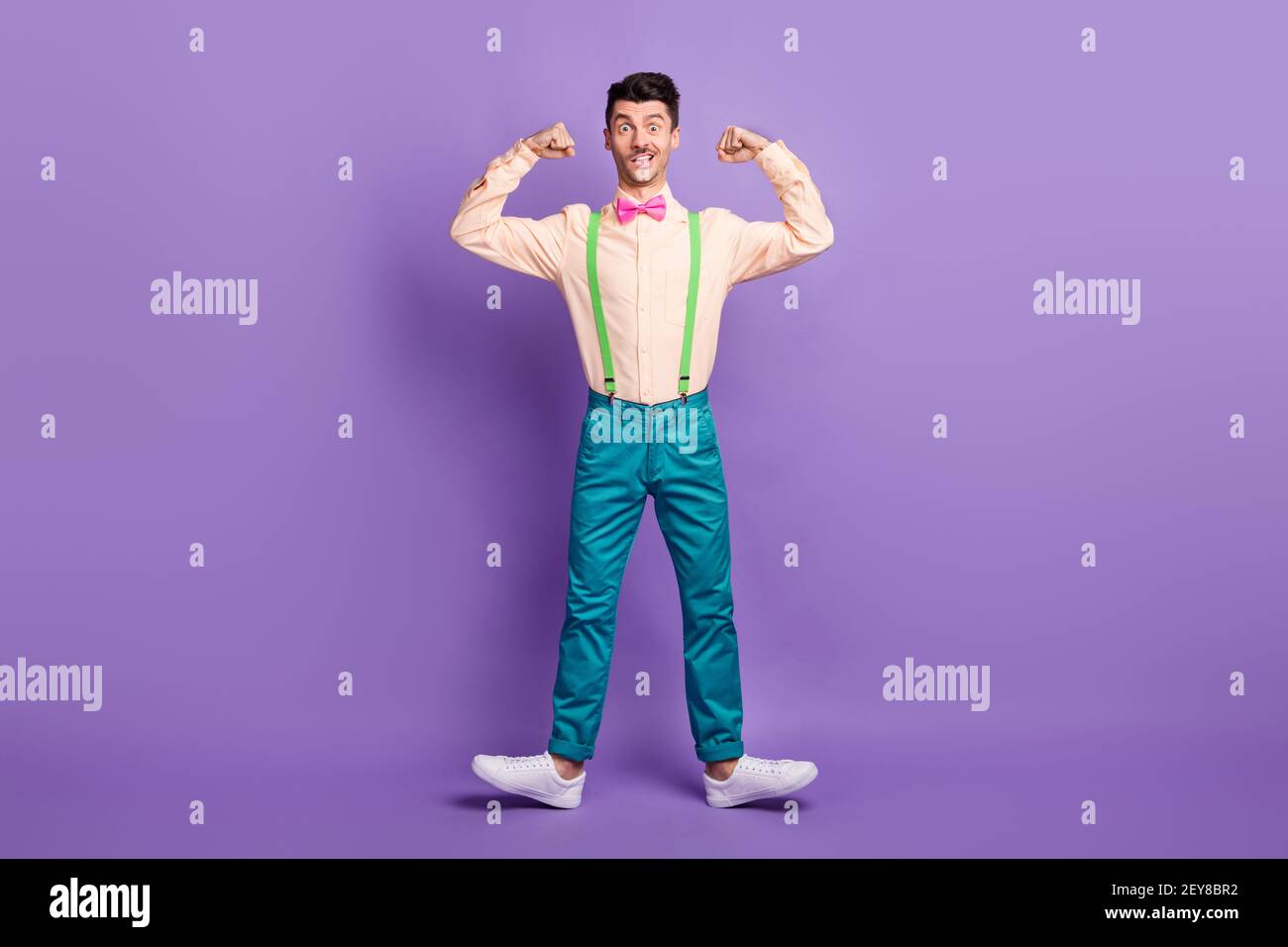 Photo of strong funny young man dressed yellow shirt showing muscles ...