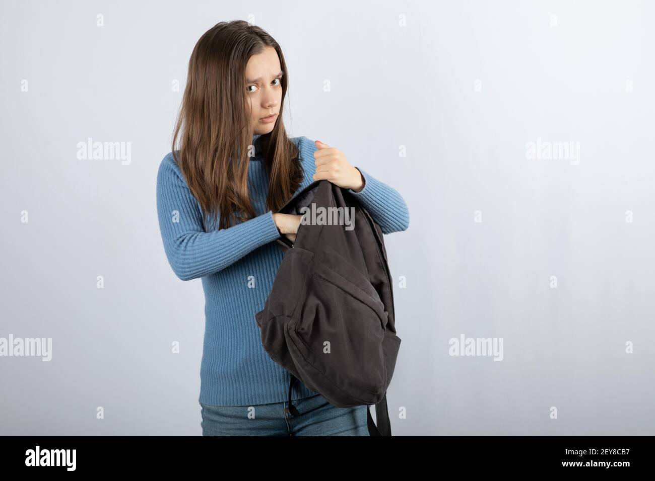Portrait photo of a young girl model holding backpack and posing Stock ...