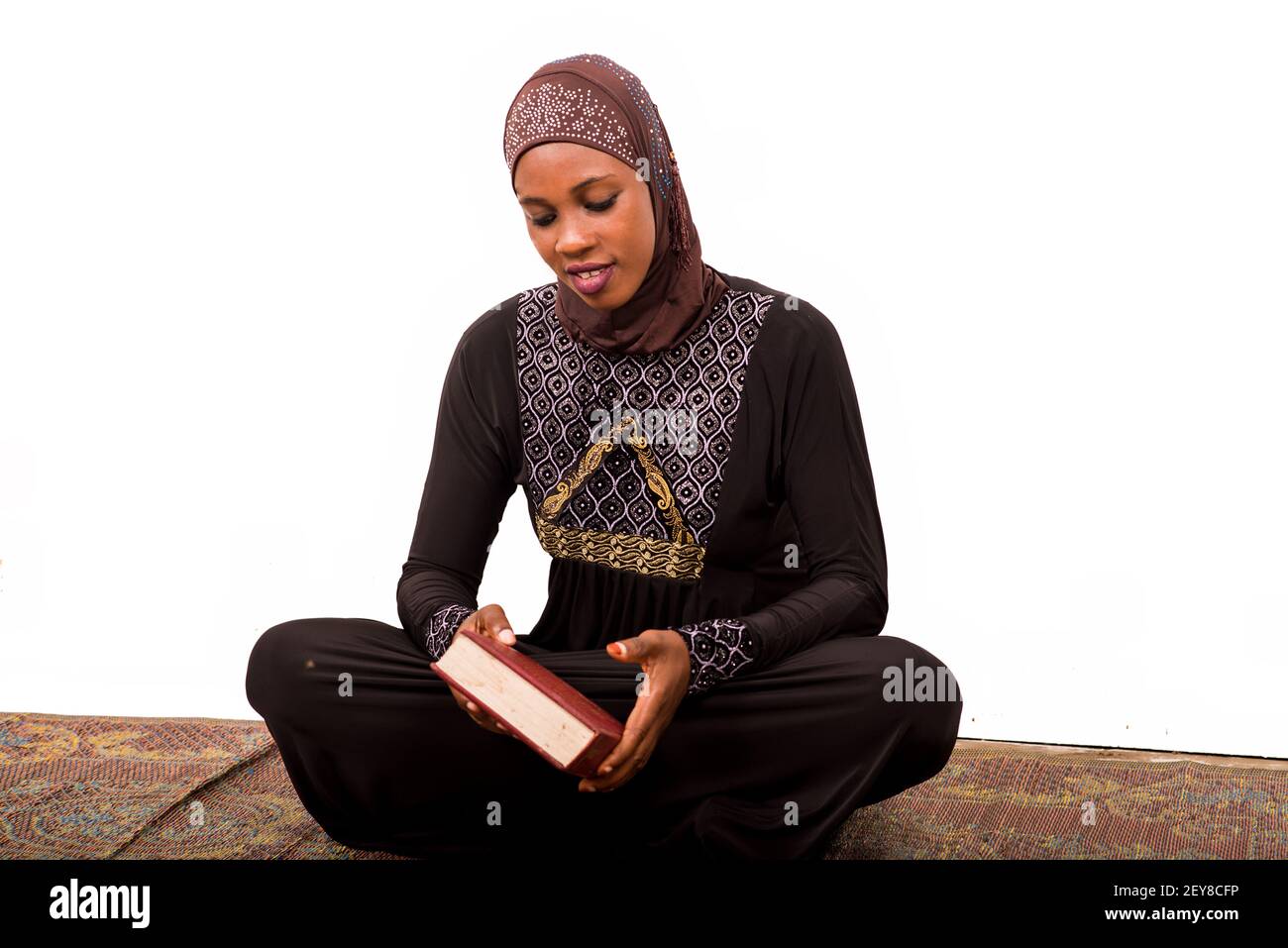 young muslim woman sitting on a mat watching the koran smiling Stock ...