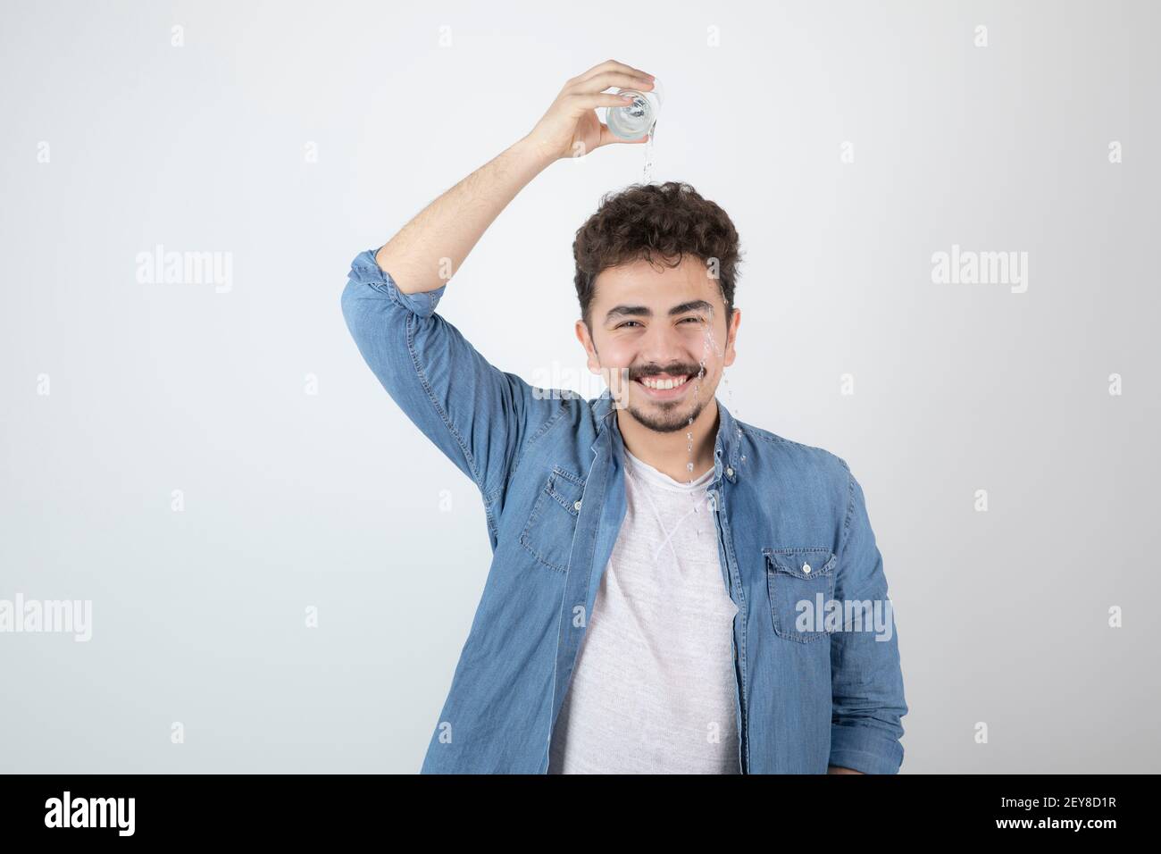 Photo of a smiling attractive man standing and holding a glass jar ...