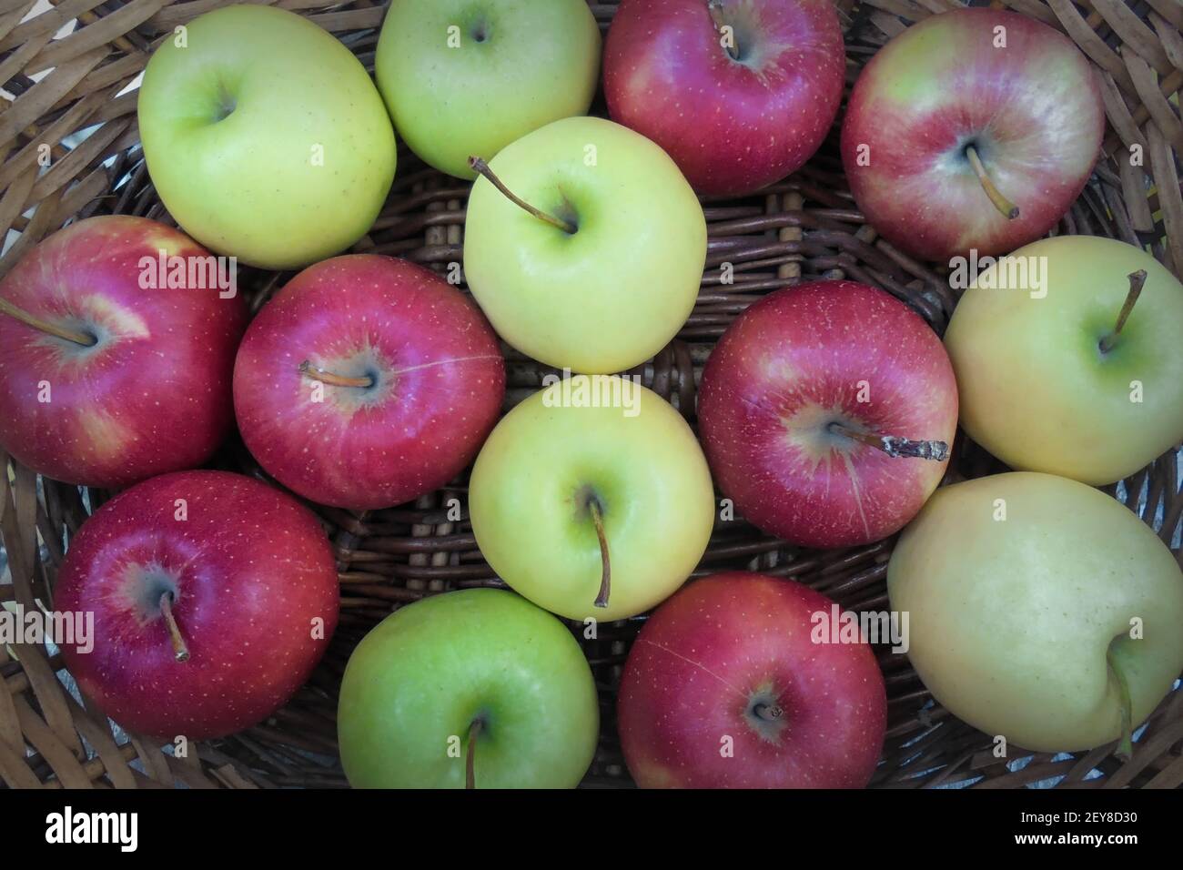 red, green and yellow apples in a wicker basket top view Stock Photo ...