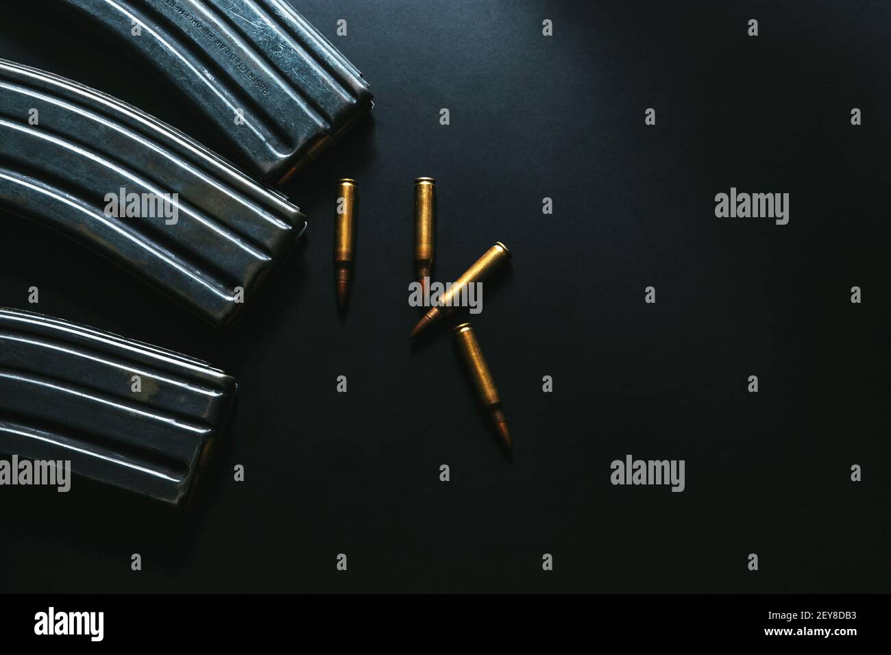 A top view of gun magazines and bulle on a black surface background ...