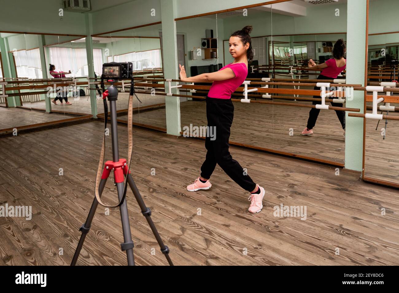 Young woman recording on camera a dance lesson in a choreography hall ...