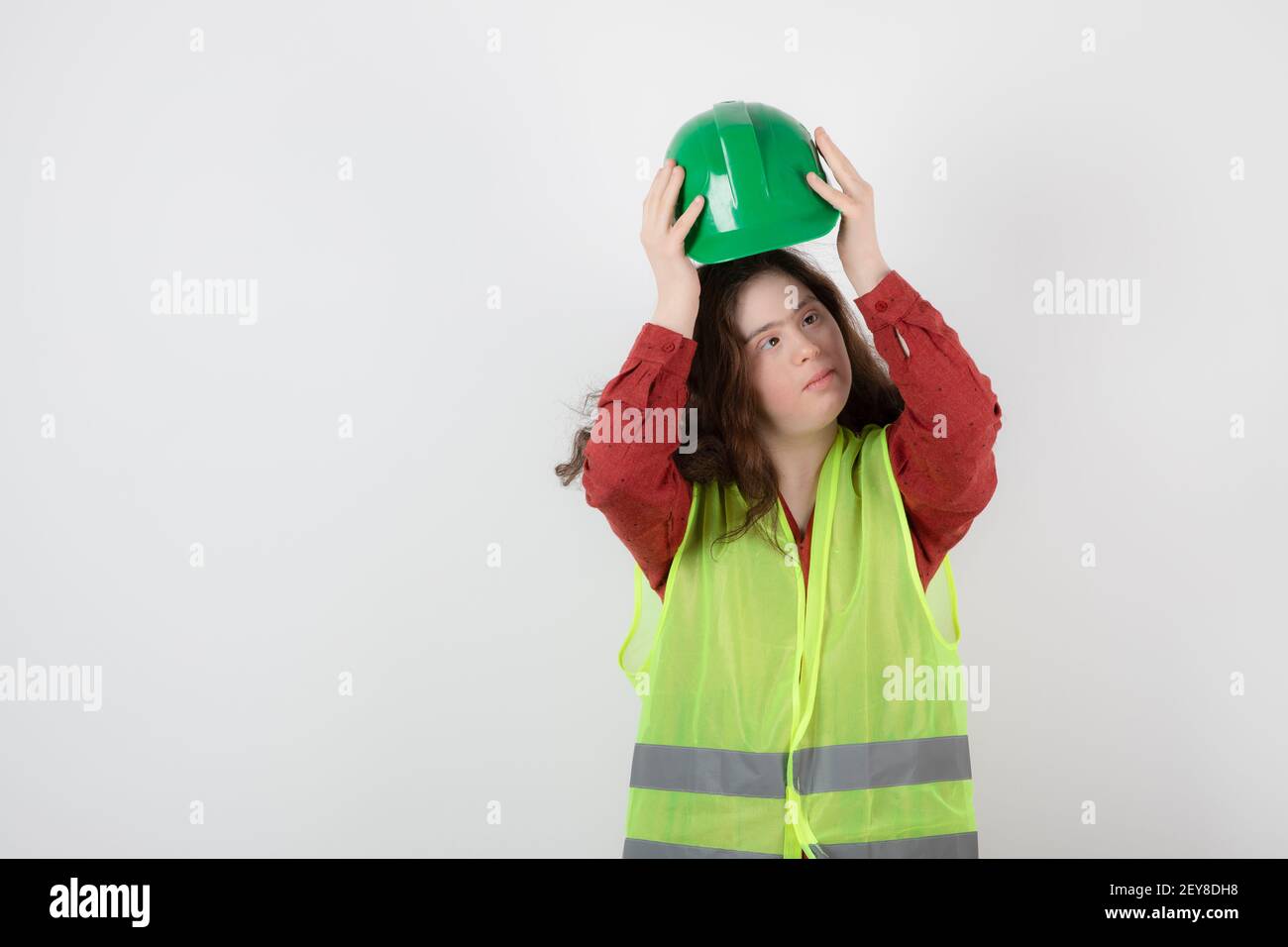Image of a young cute girl standing in vest and wearing a crash helmet ...