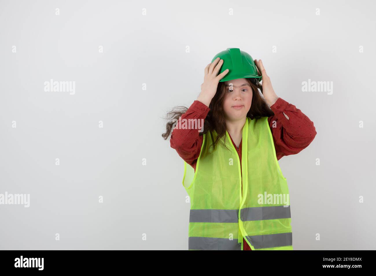 Image of a young cute girl standing in vest and wearing a crash helmet ...