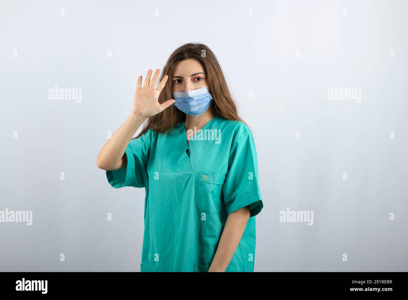 Young beautiful nurse in green uniform wearing a medical mask Stock ...