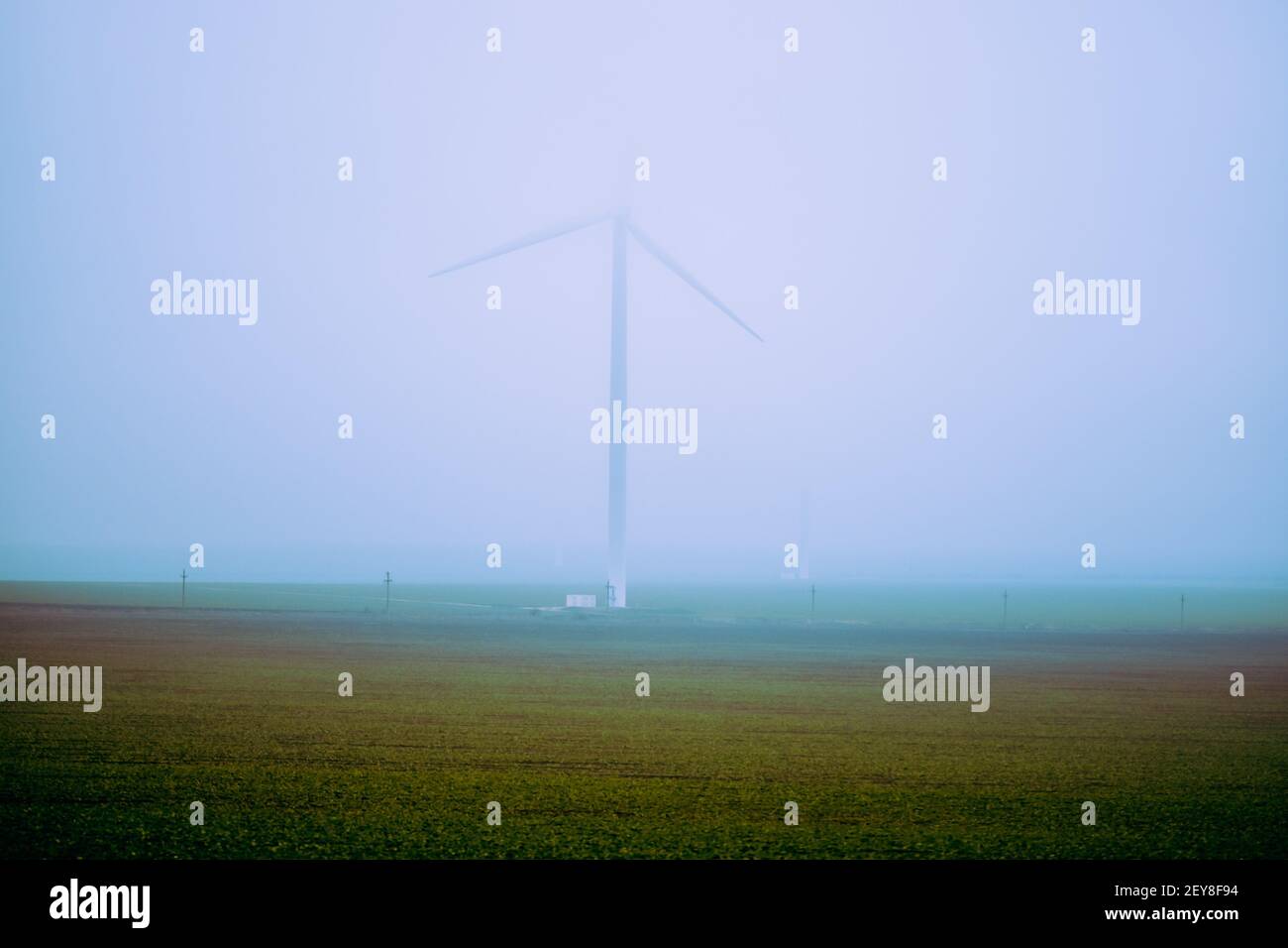 A tall windmill in a land with a foggy background Stock Photo - Alamy