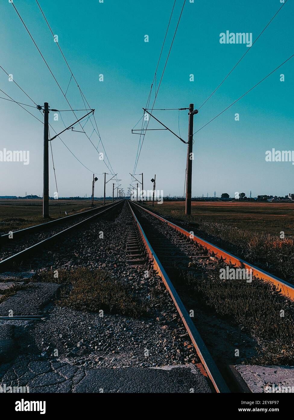 A vertical shot of train tracks surrounded by electricity wires Stock ...