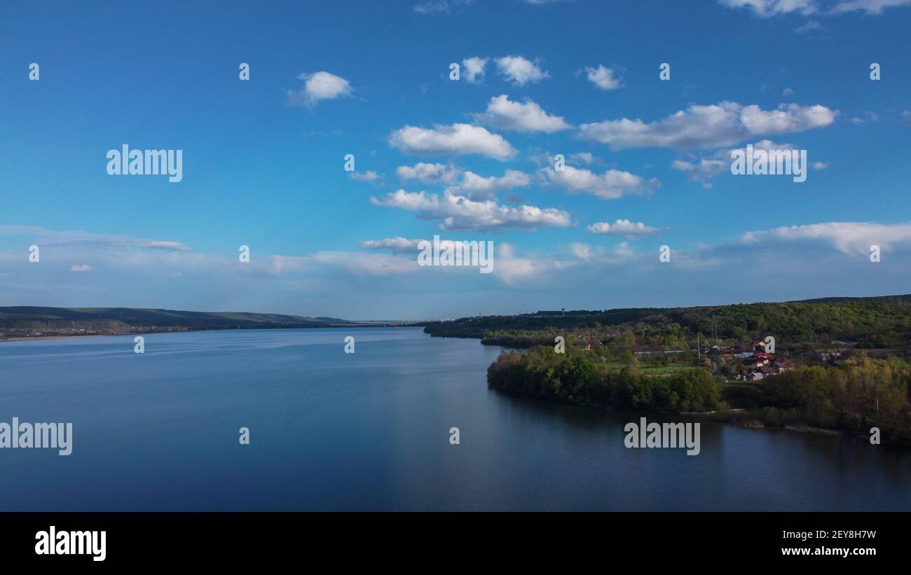 An aerial of a landscape with a flowing river gleaming under the cloudy ...