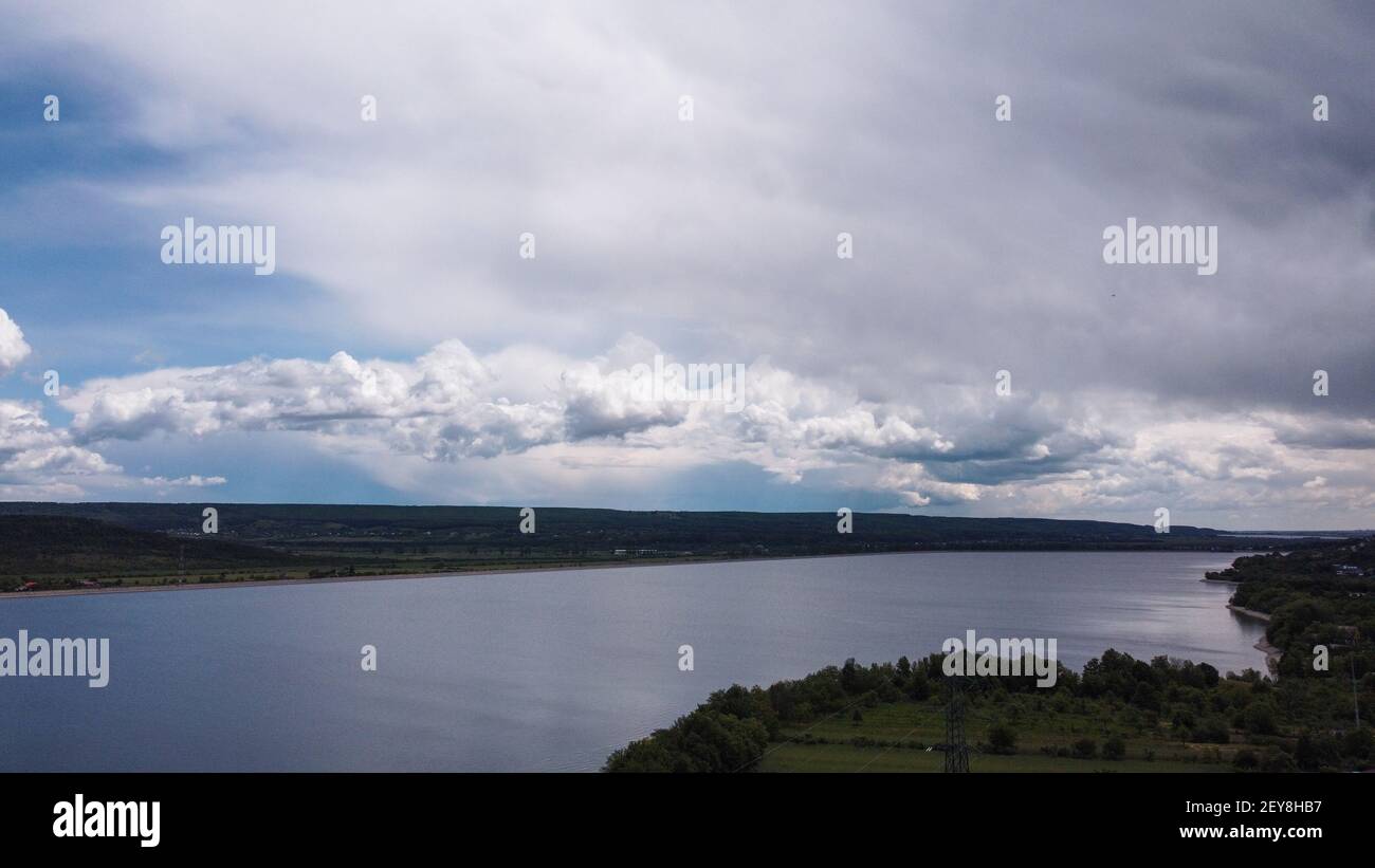 A tranquil view of a wide river under a cloudy sky Stock Photo - Alamy