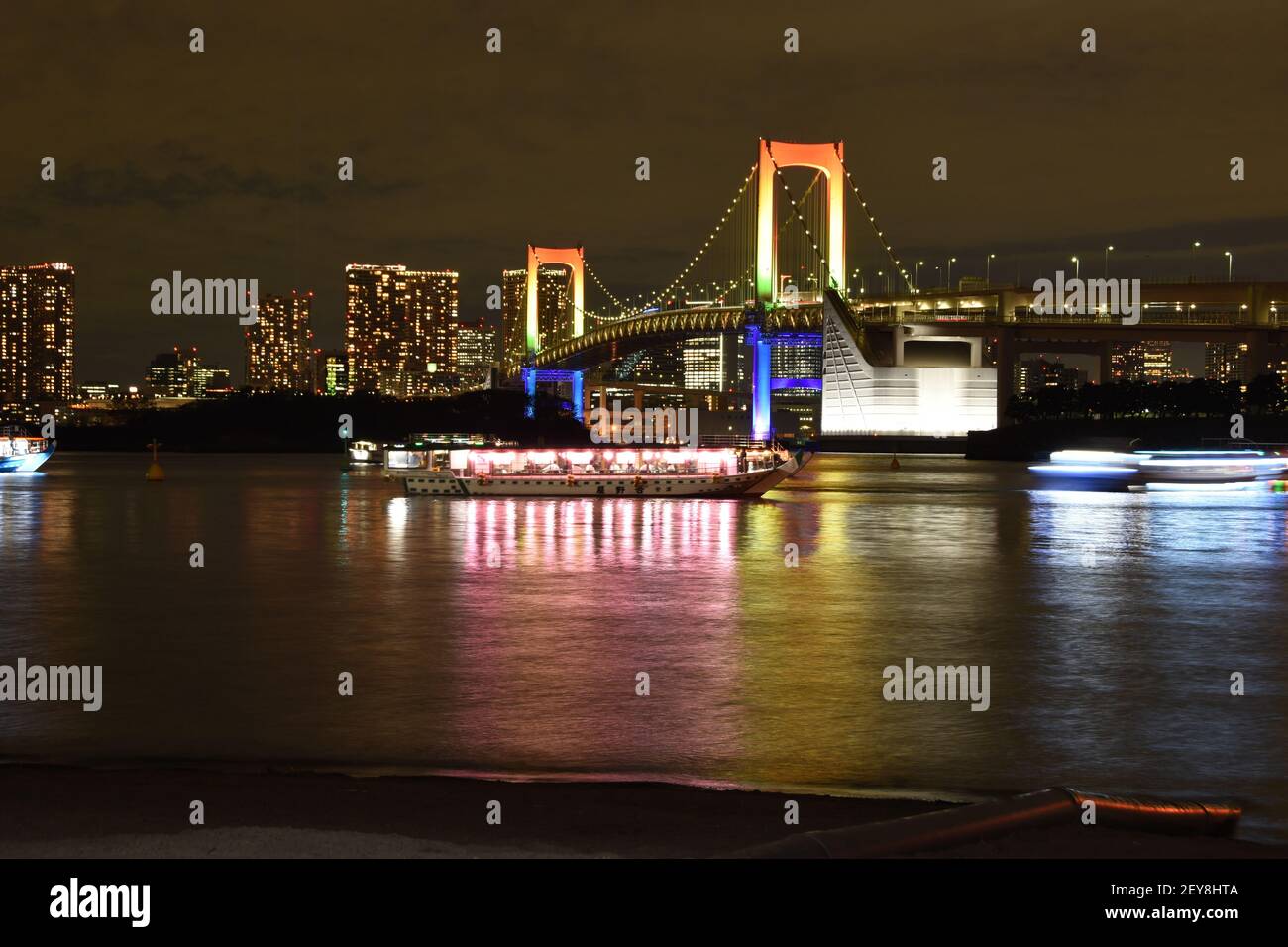 A ship passing under the Rainbow Bridge at night in Tokyo Stock Photo ...