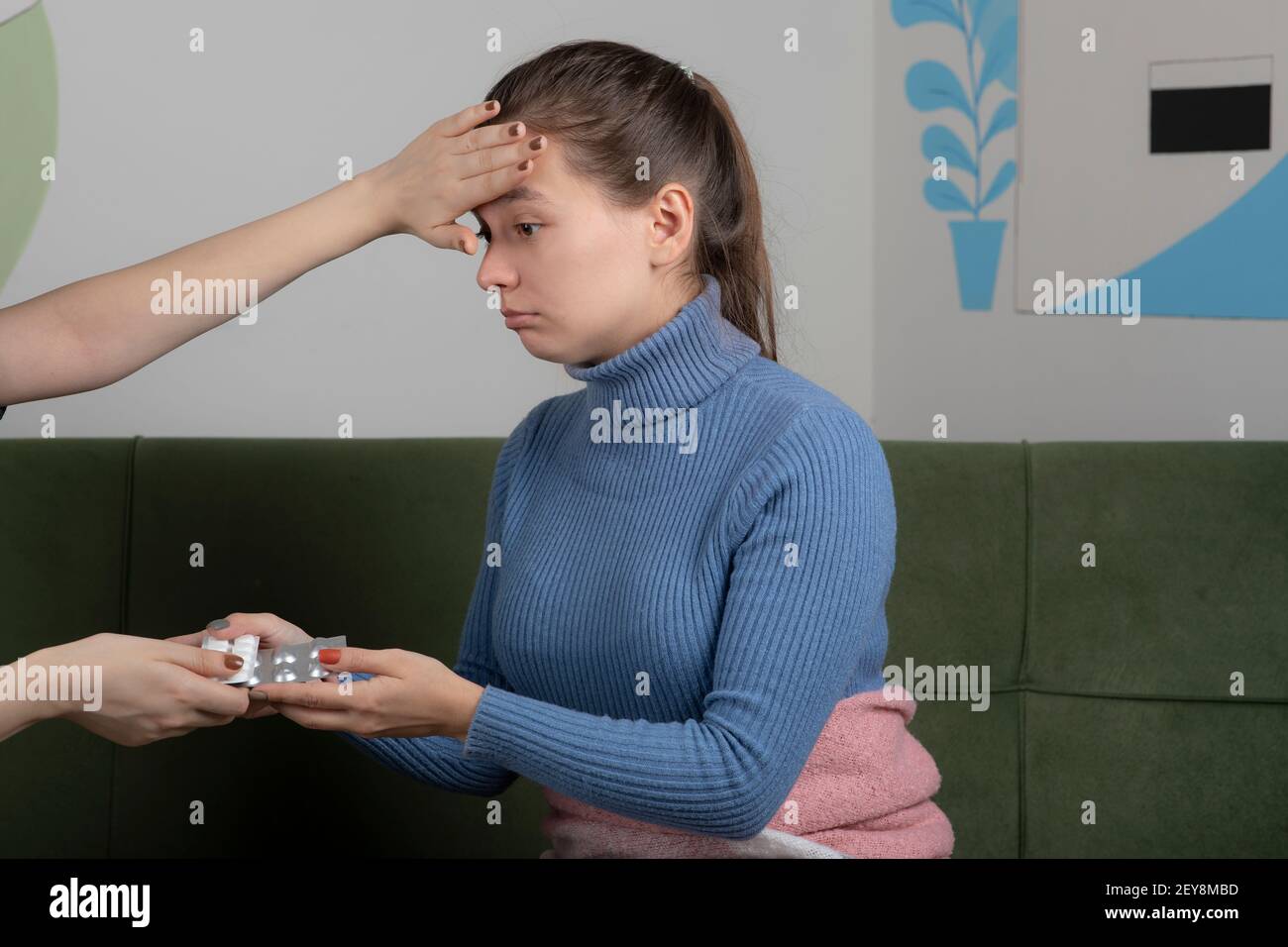Image of sick girl getting check up by her friend while sitting on the ...