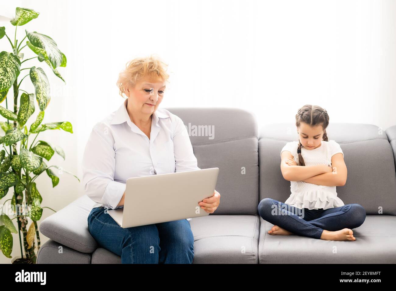 modern grandmother teaching grandchild how to use laptop computer at ...