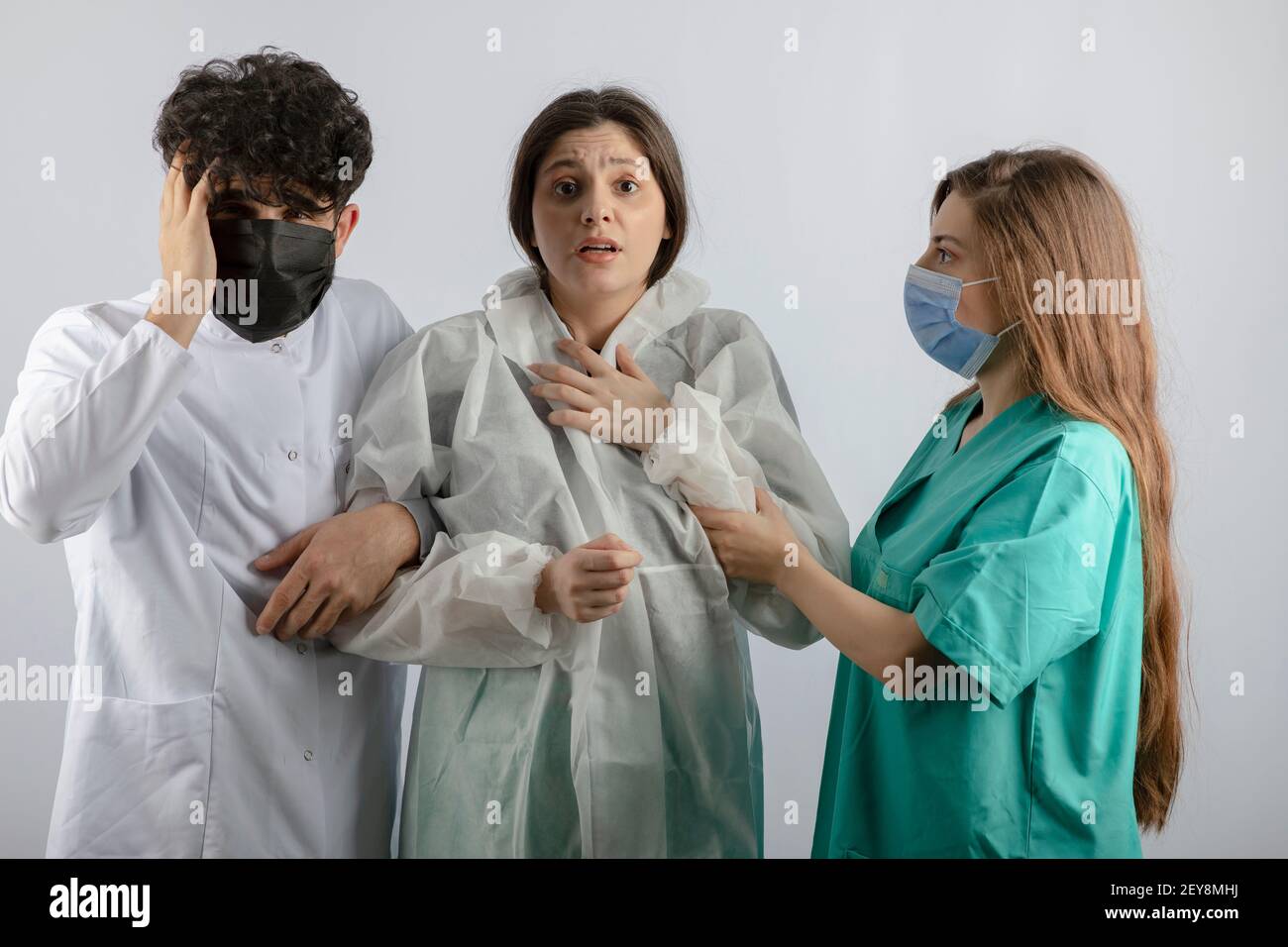 Three doctors standing and looking at camera on white background Stock ...