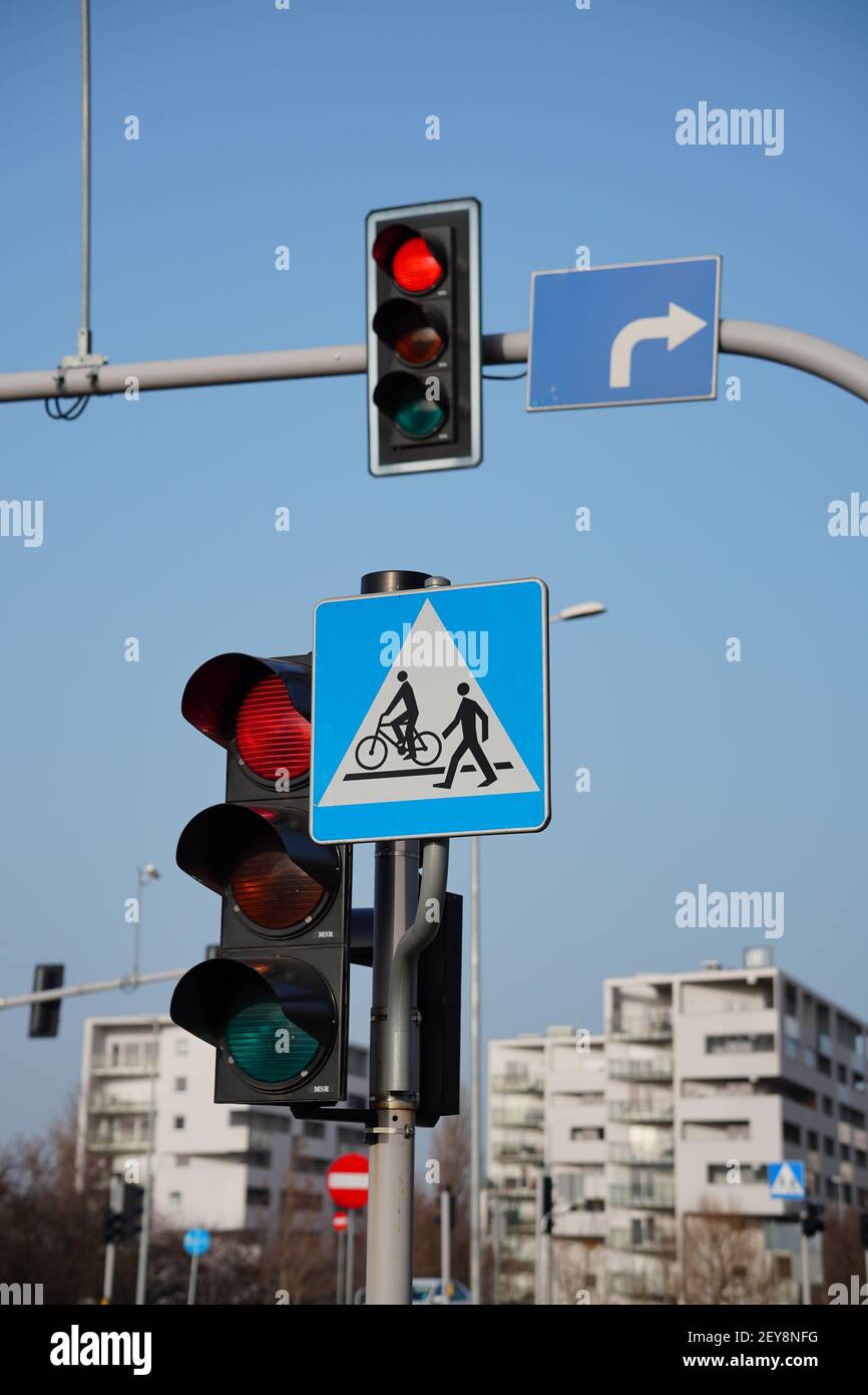 A vertical shot of traffic lights and a sign for bikers and pedestrians ...
